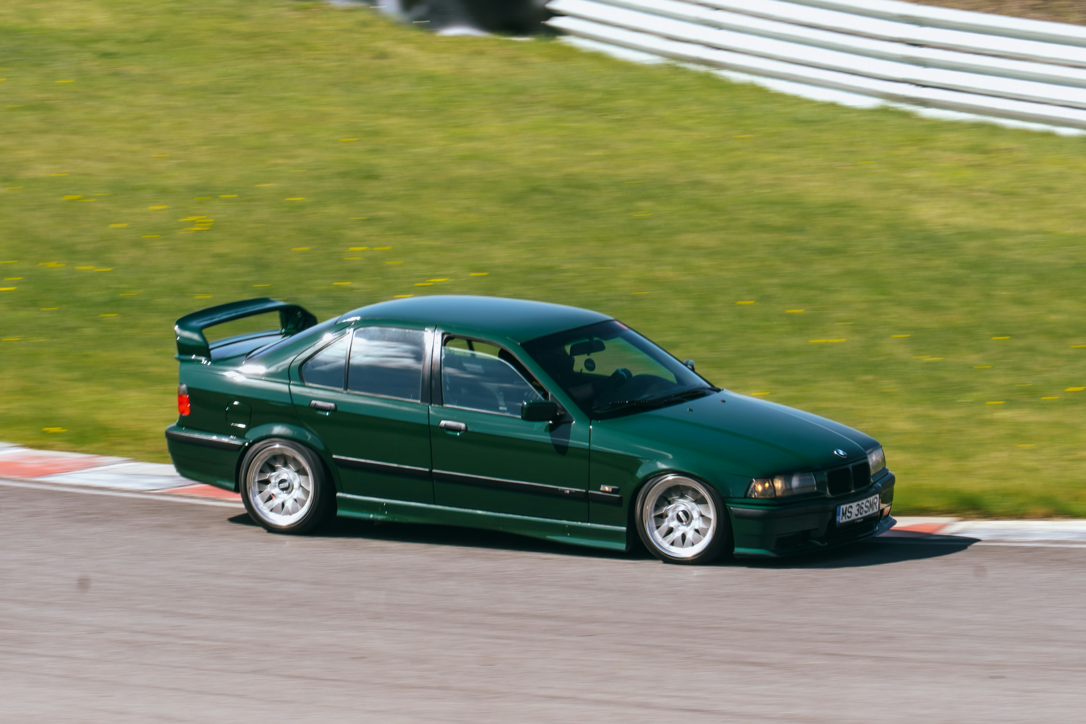 Green racer in motion: a tuned sedan bullets along the track