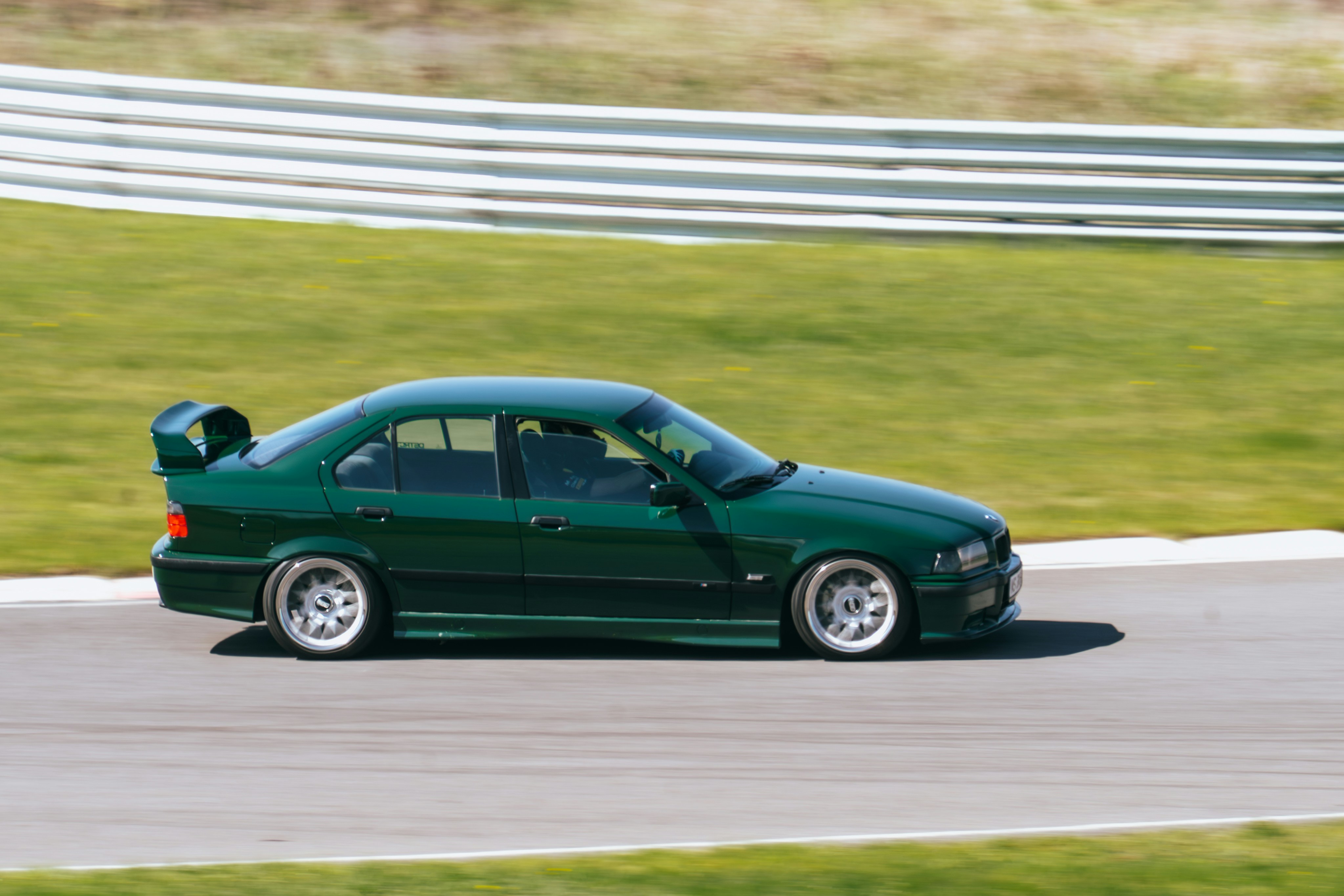 Green racer in full flight: a tuned sedan slices the track