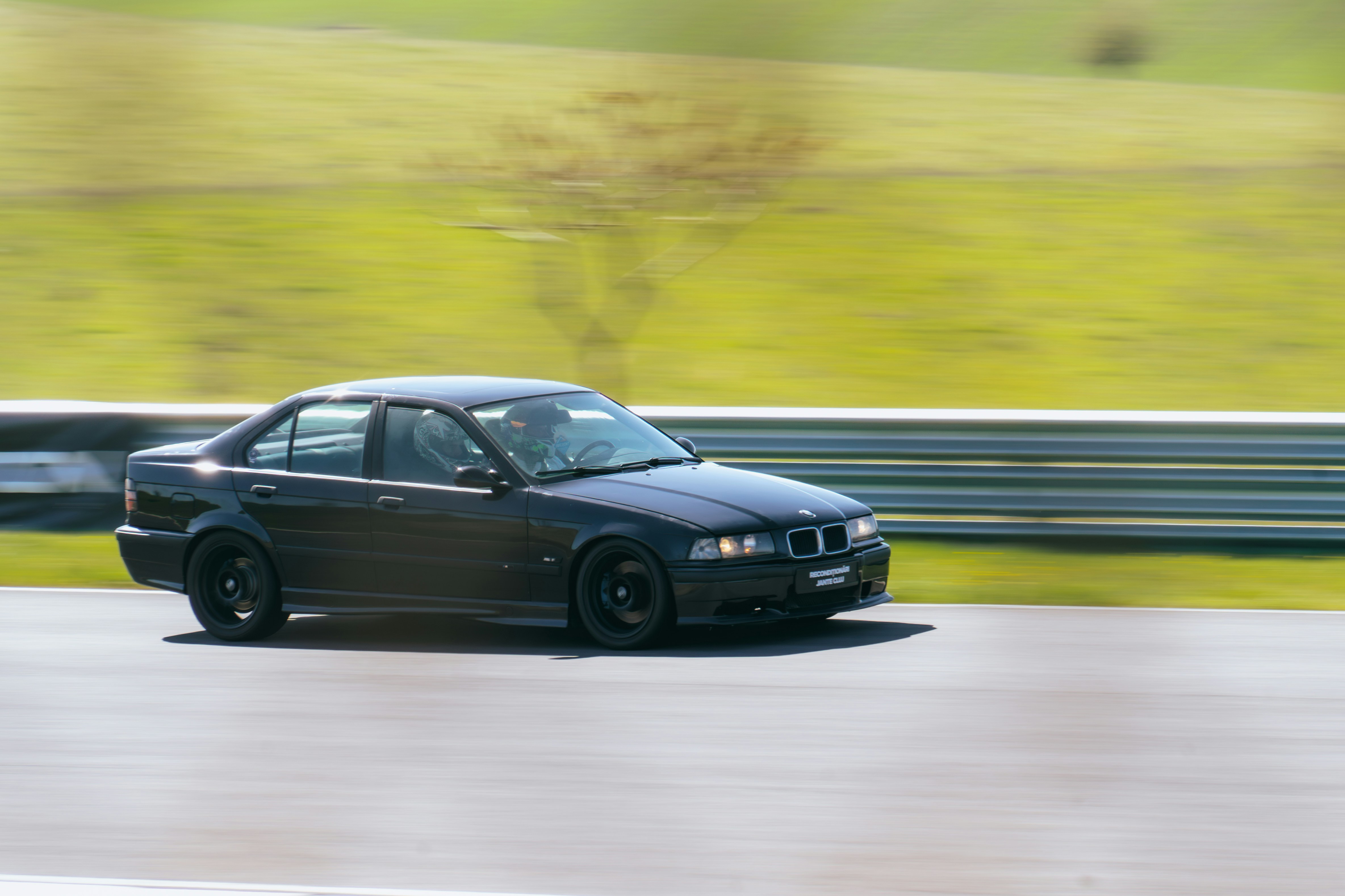Mid-Run Shadow: A Black BMW slides along a racetrack