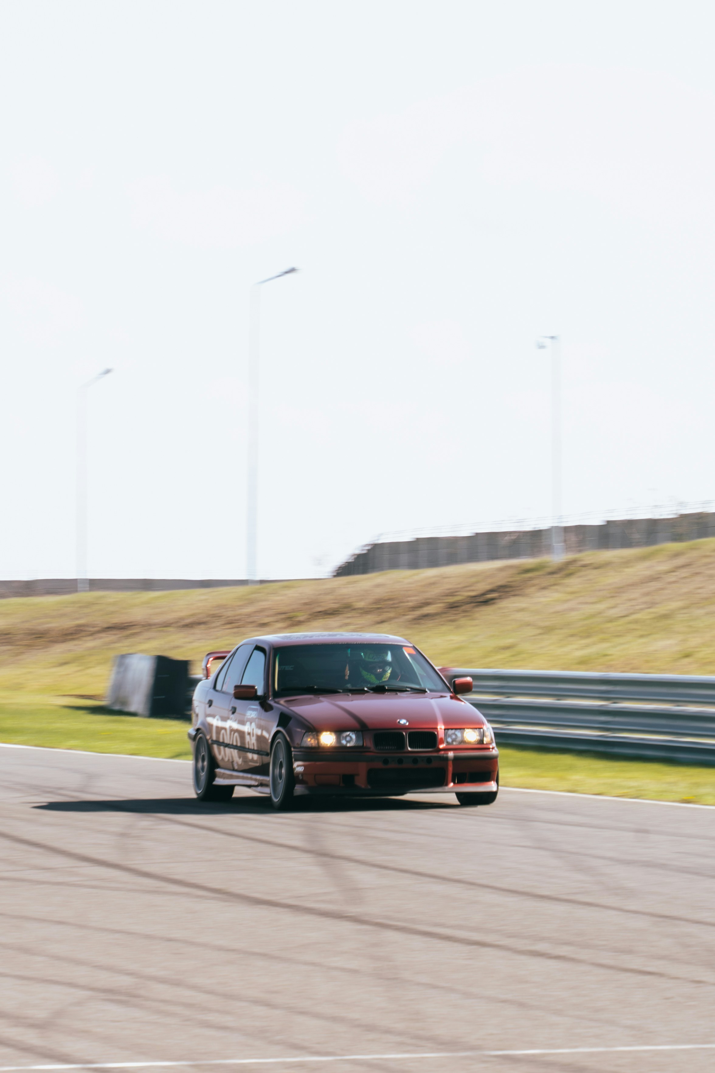 Red BMW Drifts Through a Race Track Arc at Dusk