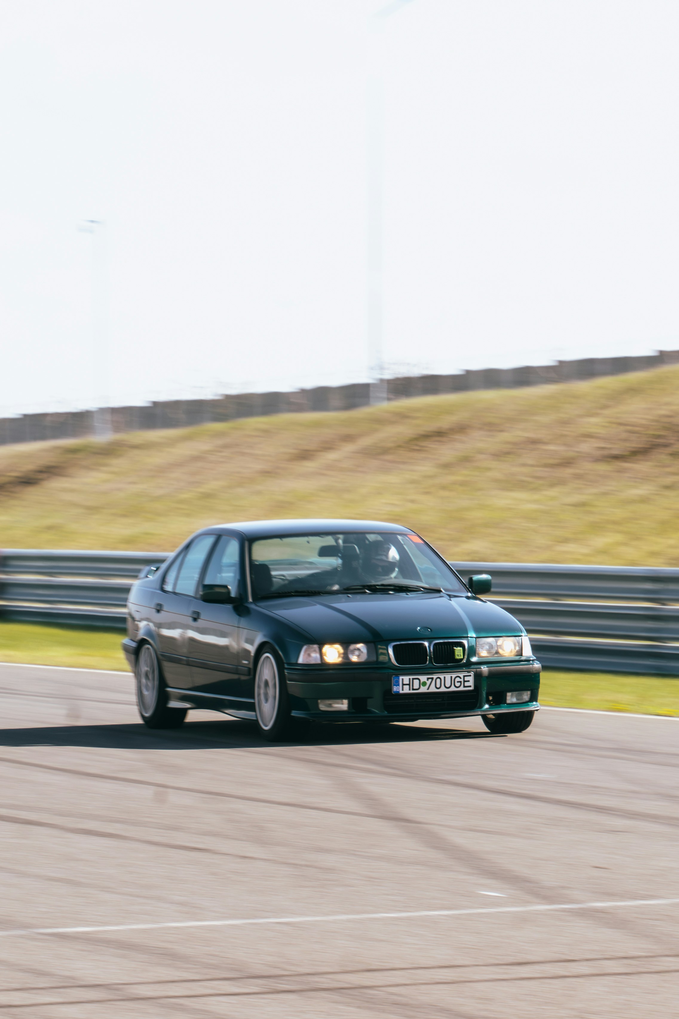 Green BMW on a Race Track: Mid-Flight Focus
