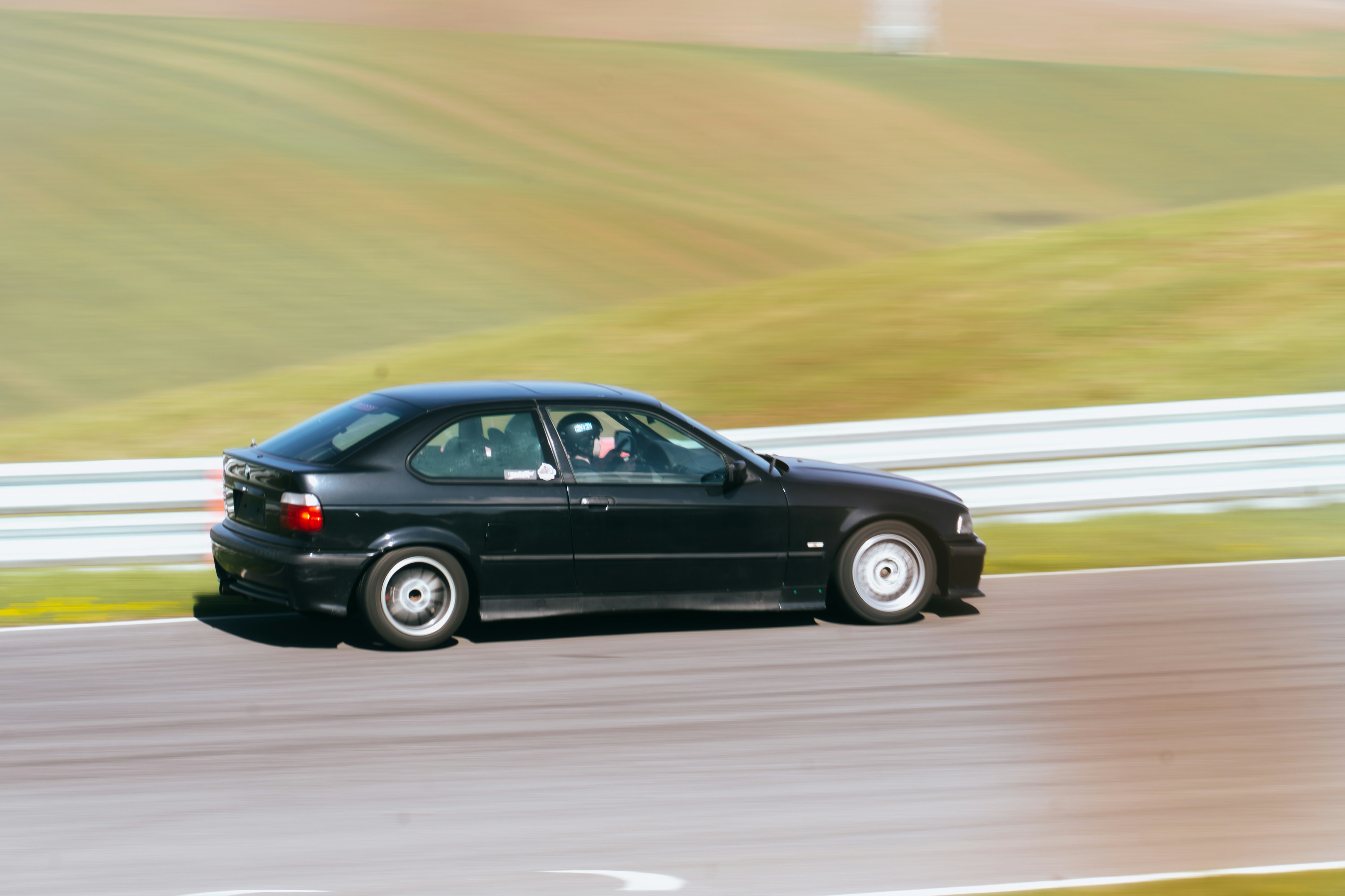 Low-slung Black Coupe in Motion on a Racing Circle
