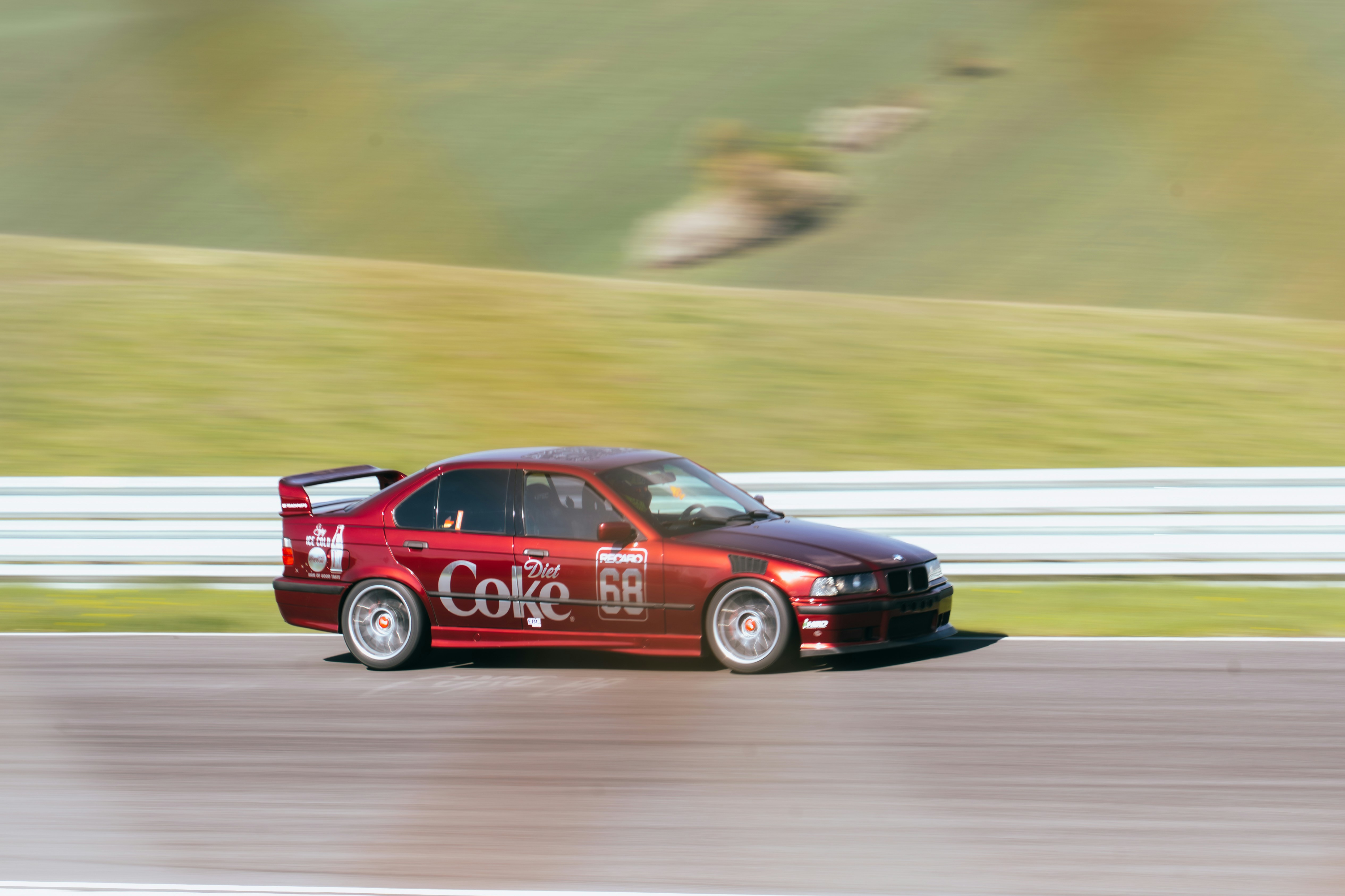 Red race car in motion blur across the straight