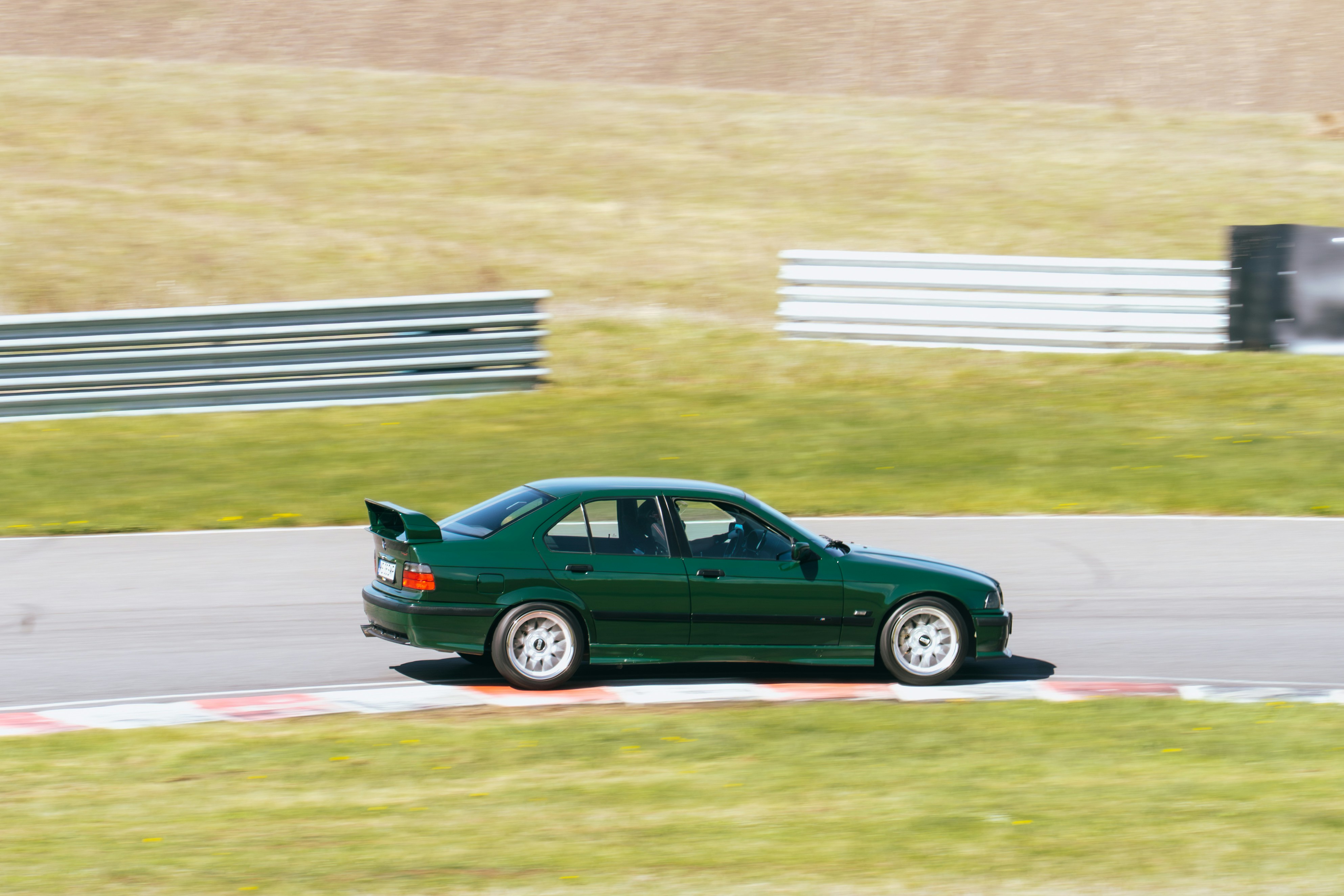 Green Racing Sedan in Focus: A Moment on the Edge of the Track