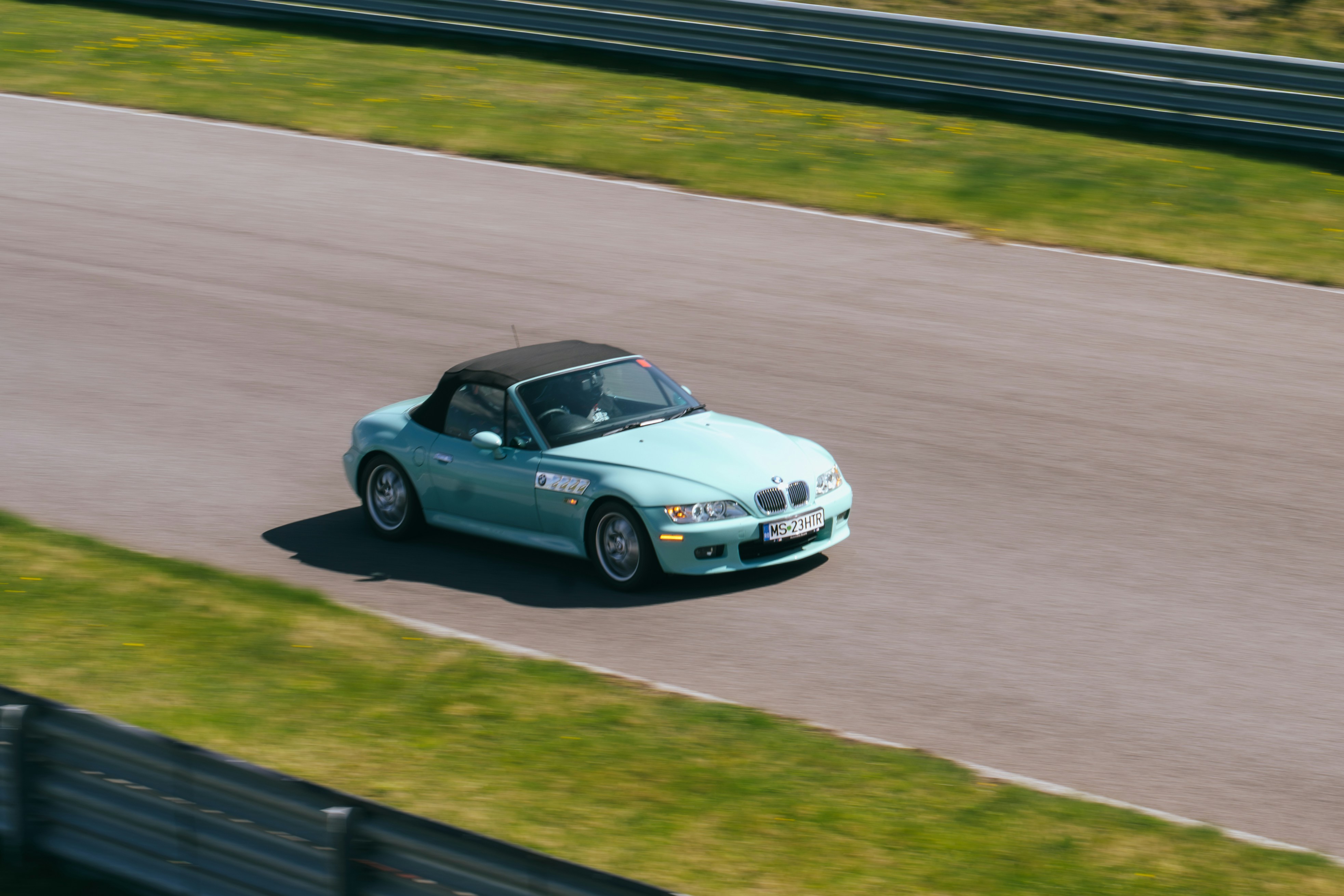 Turquoise Convertible in Motion on a Racetrack