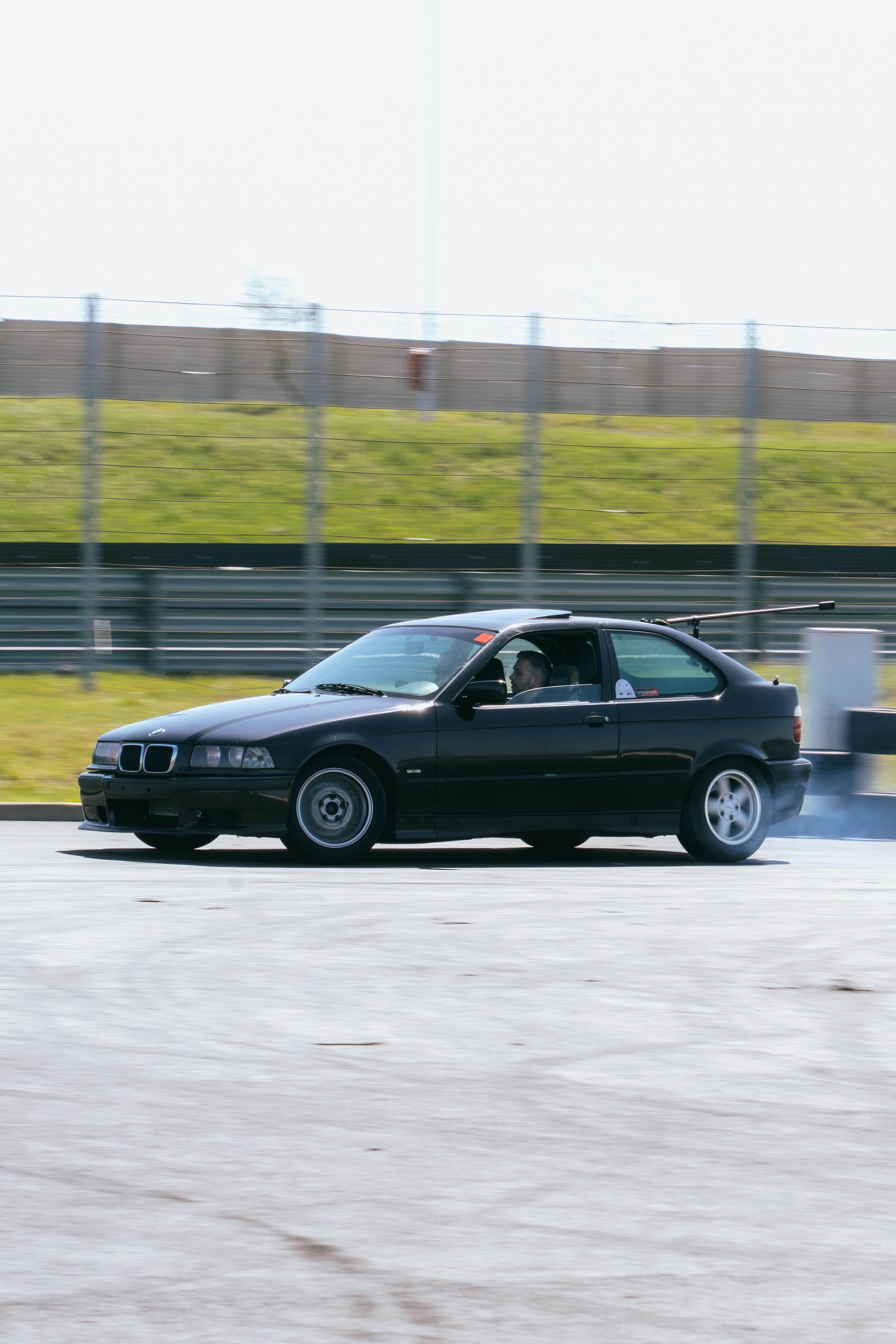 Black sedan powers through a drift on the race track