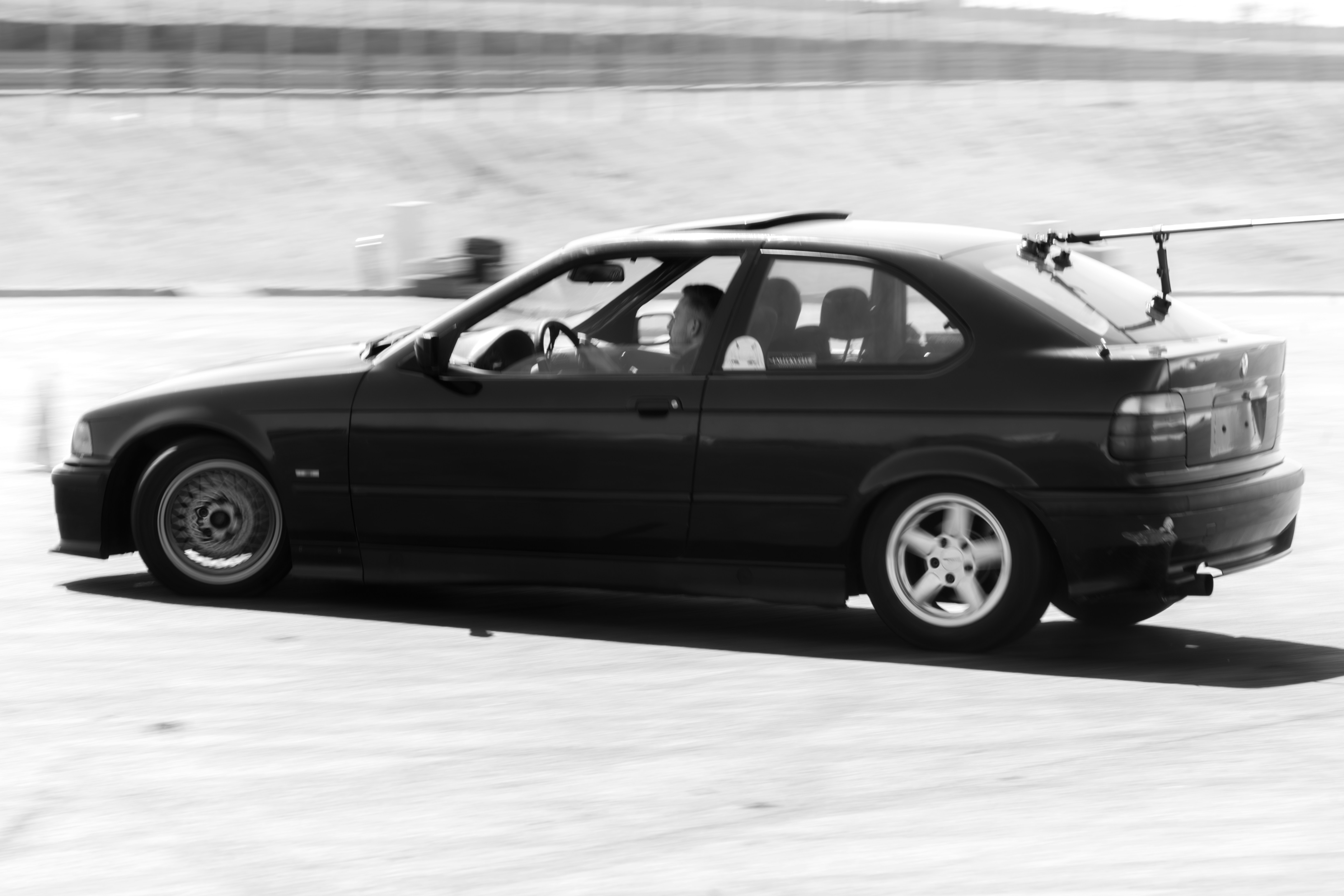 High-velocity silhouette: a drifting coupe on sunlit pavement
