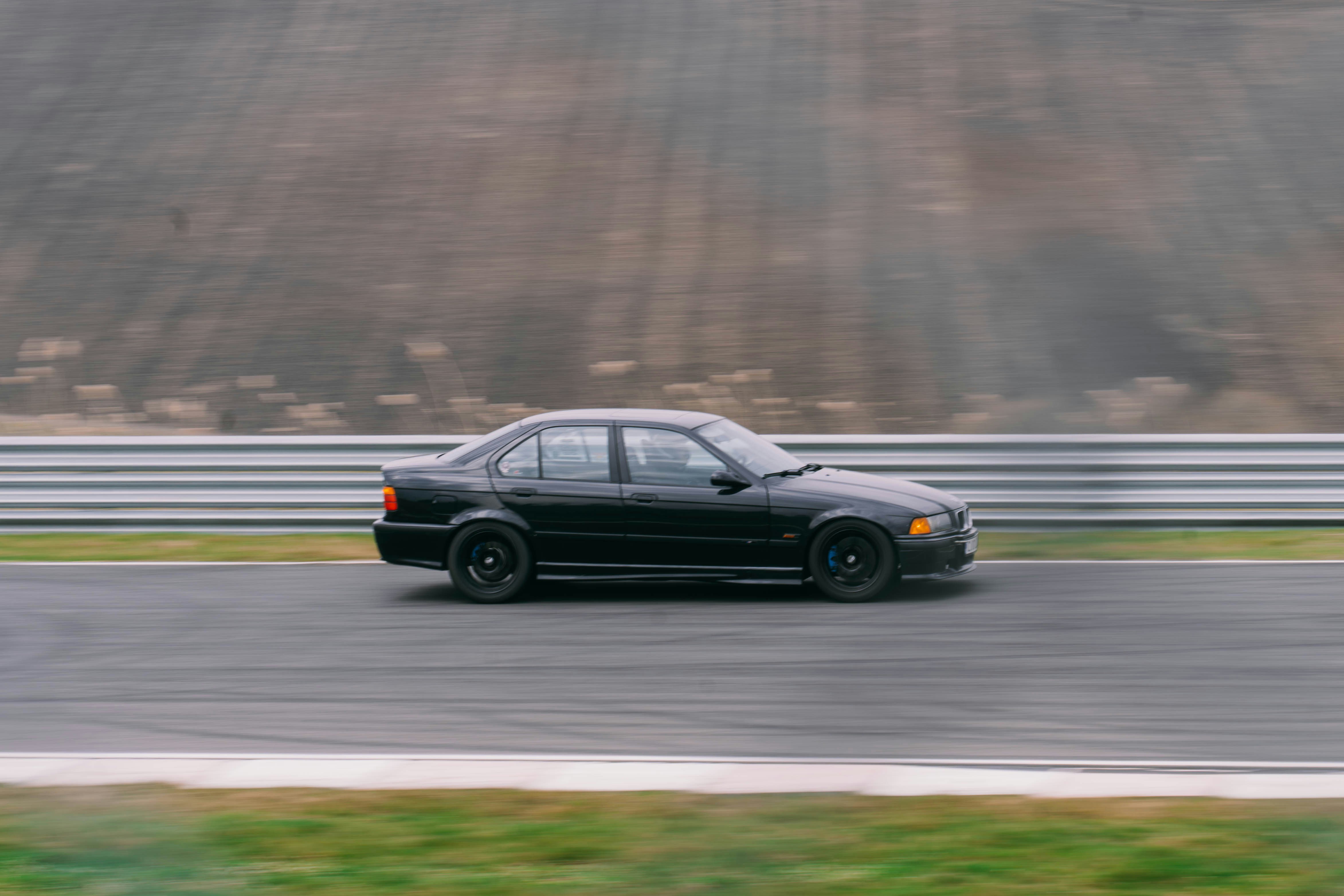 Black sedan in motion on a race track with motion blur