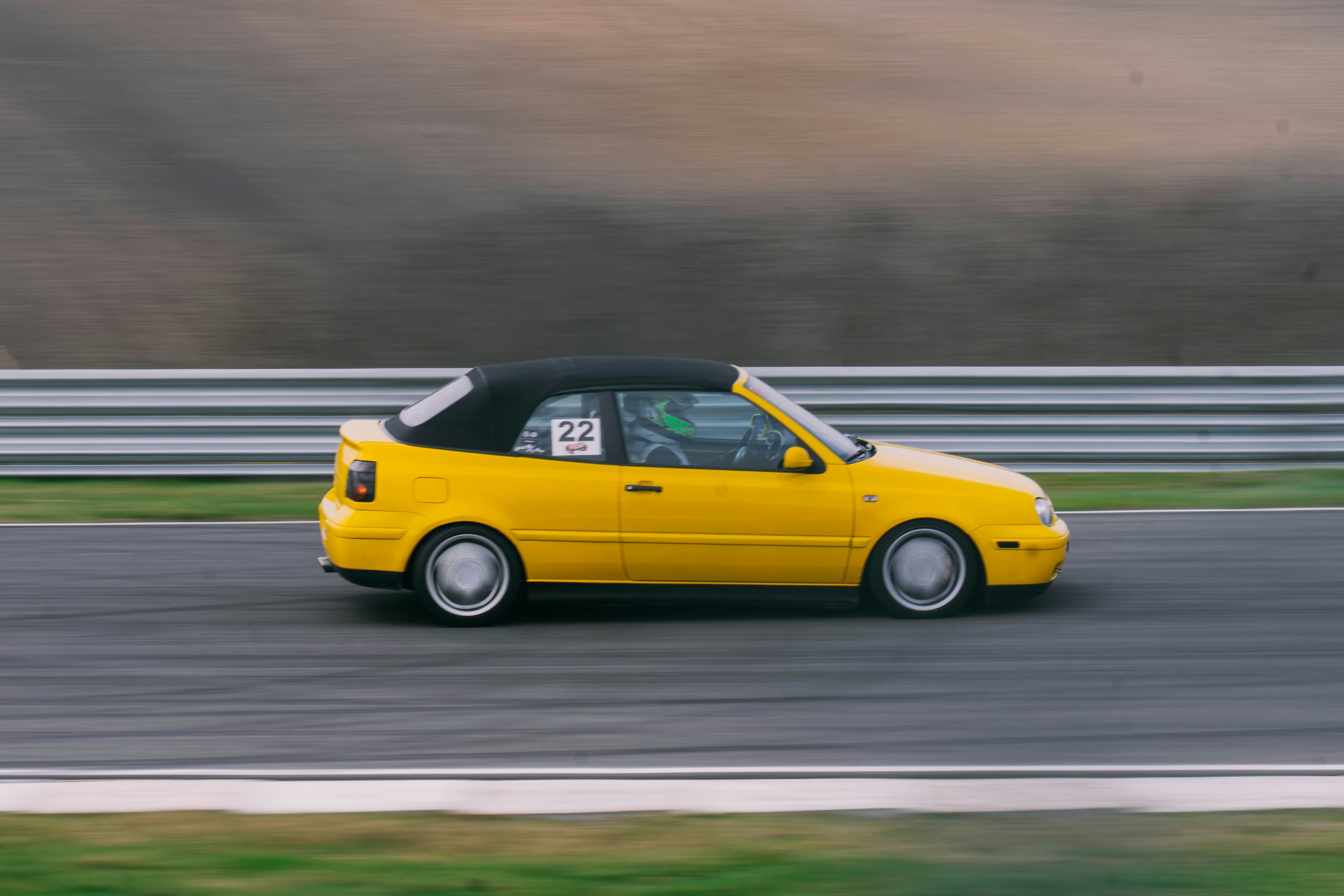 Yellow Race Car in Motion on a Gray Raceway