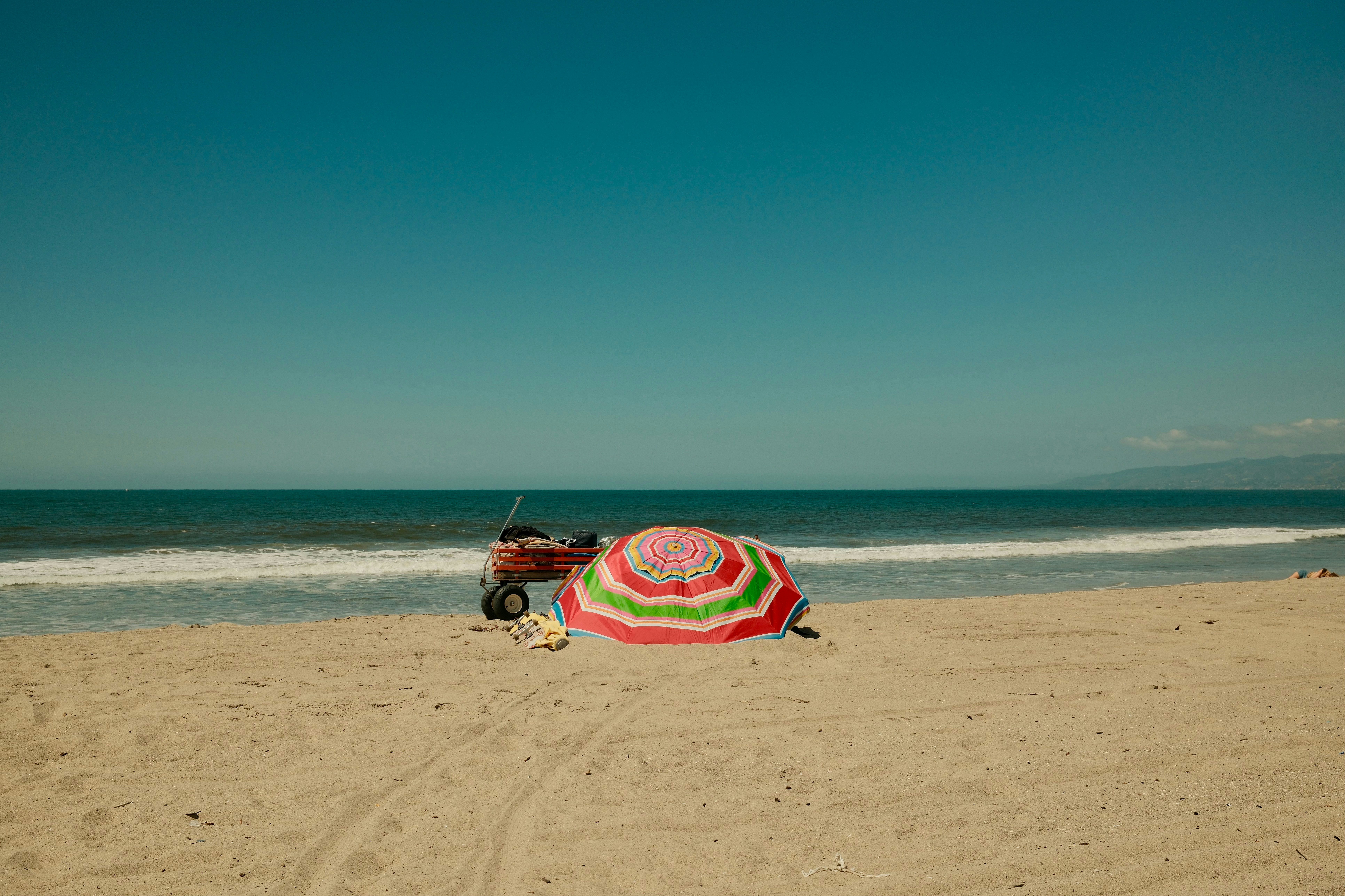 Strawberry-red Umbrella on Wind-Swept Shore