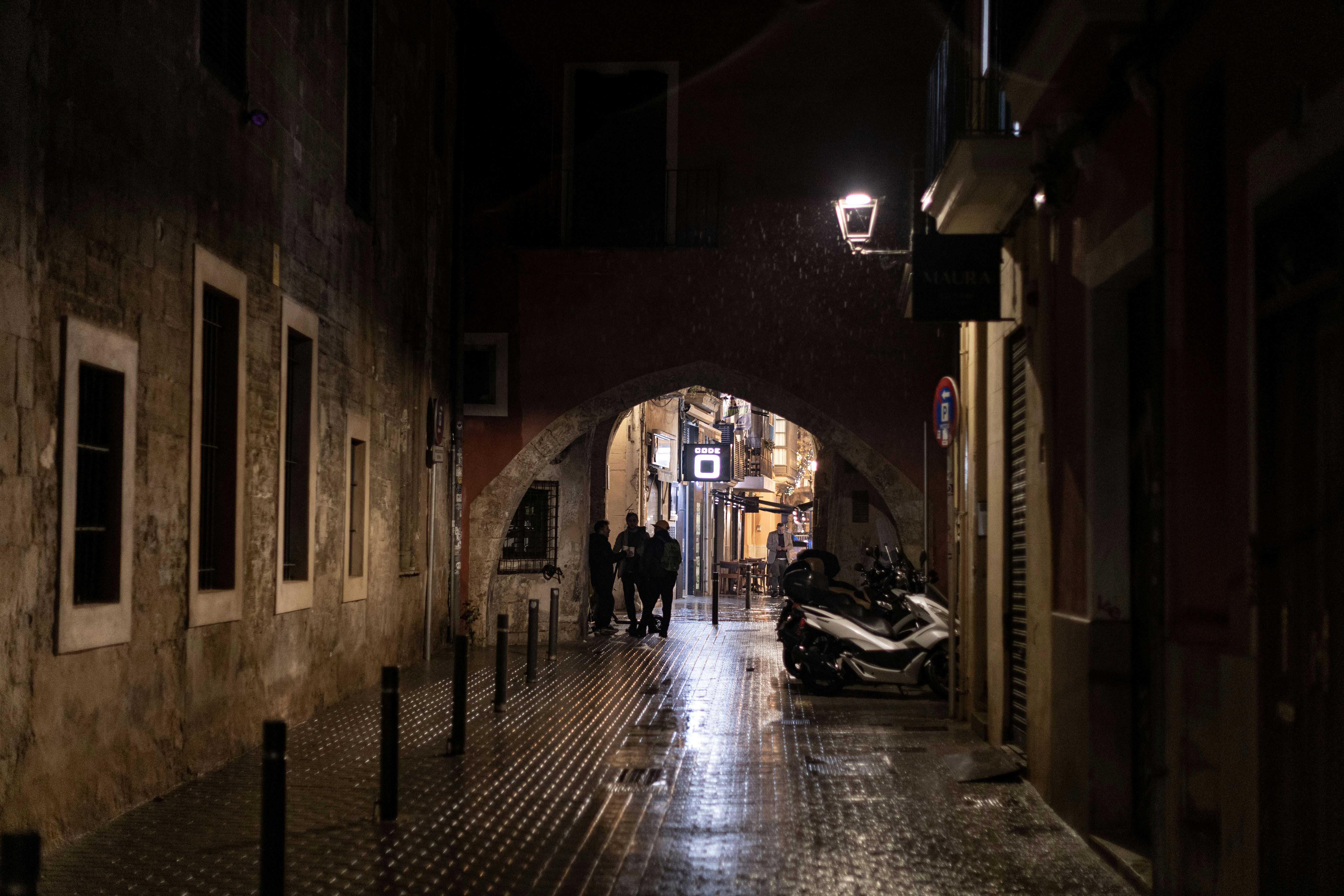 Lantern-lit Alley Through the Arch to a Quiet Plaza