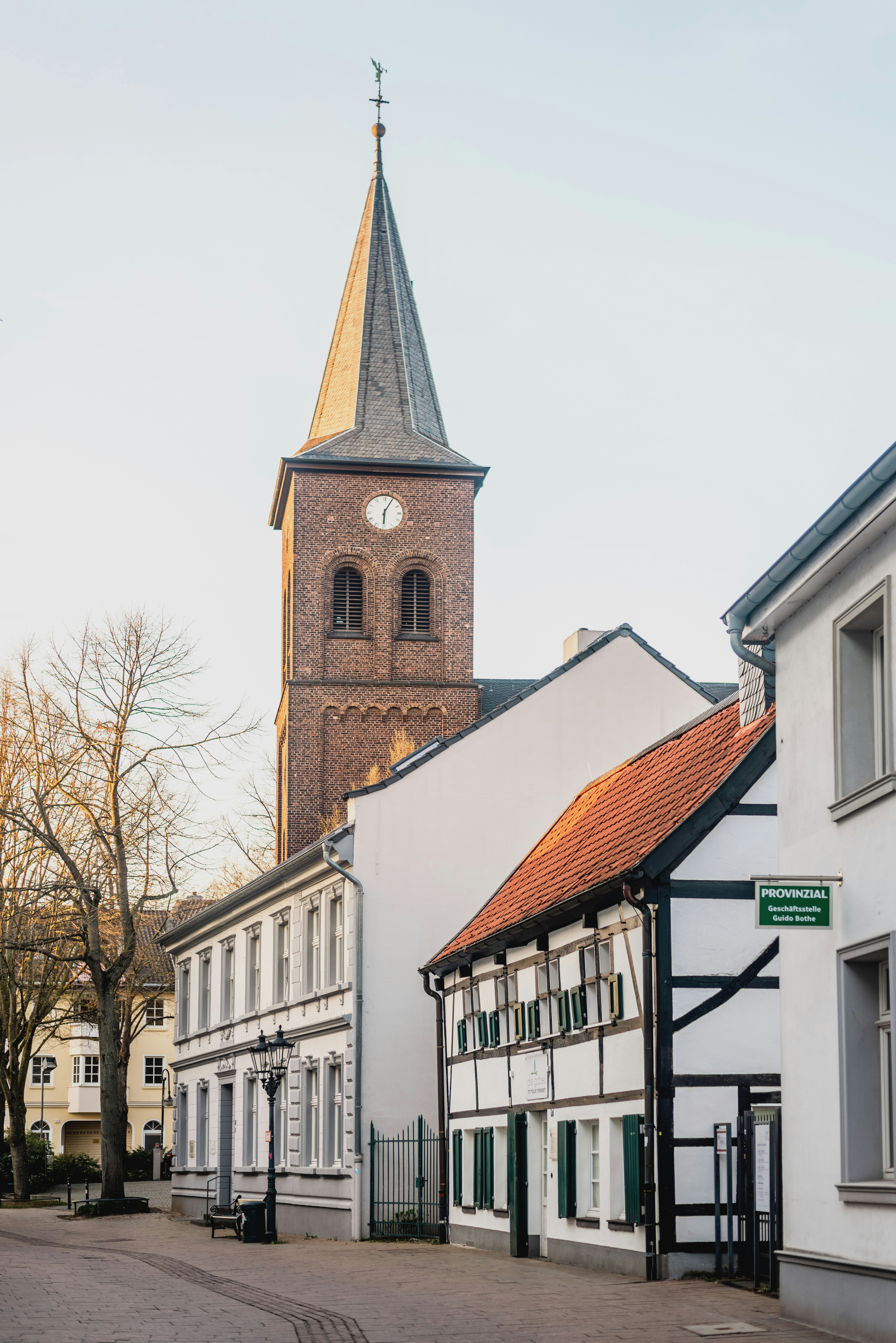 Towering Time: A Sunlit Clock Tower Over a Quiet European Street