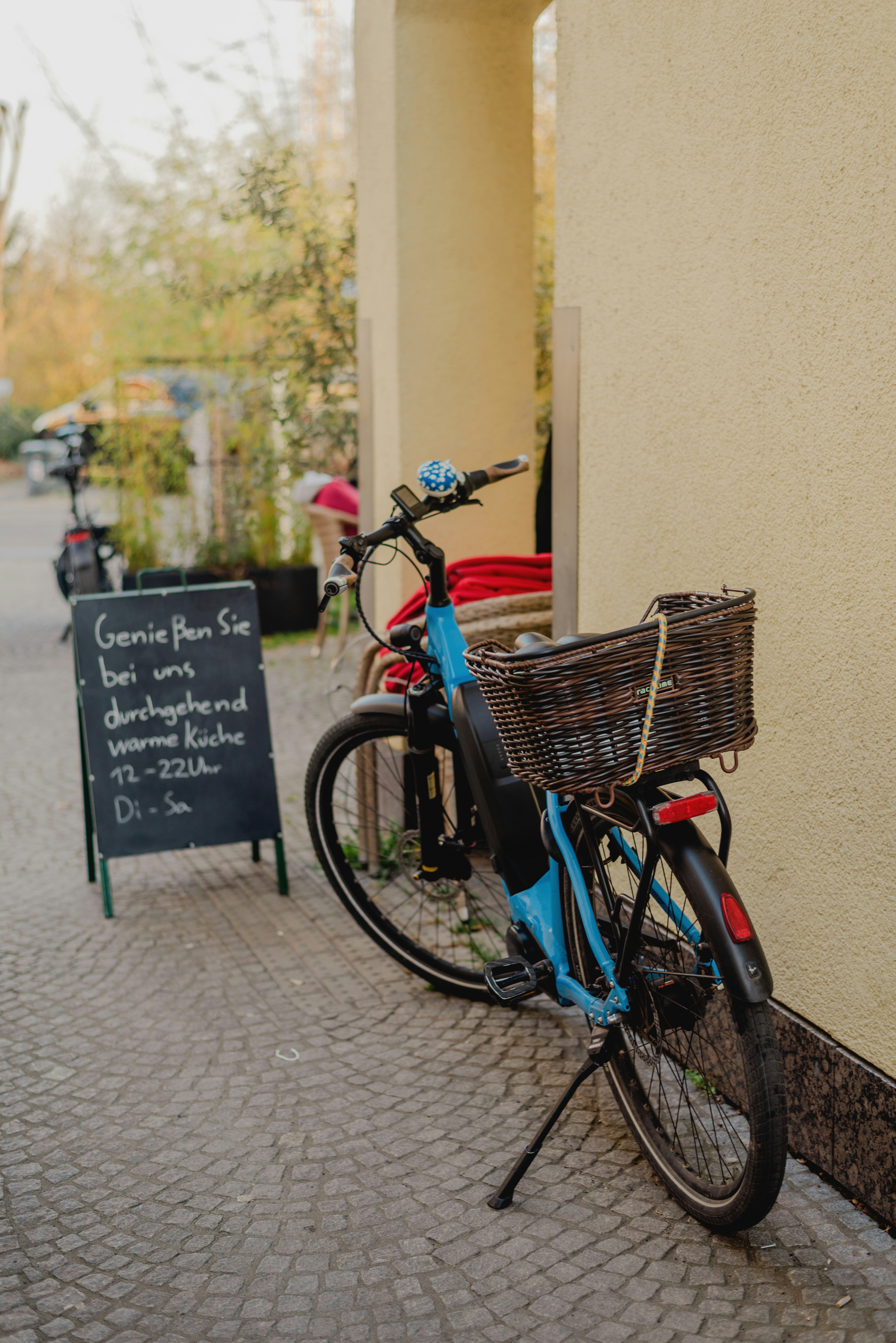 Blue Bicycle with Wicker Basket by a Quiet Cobblestone Path