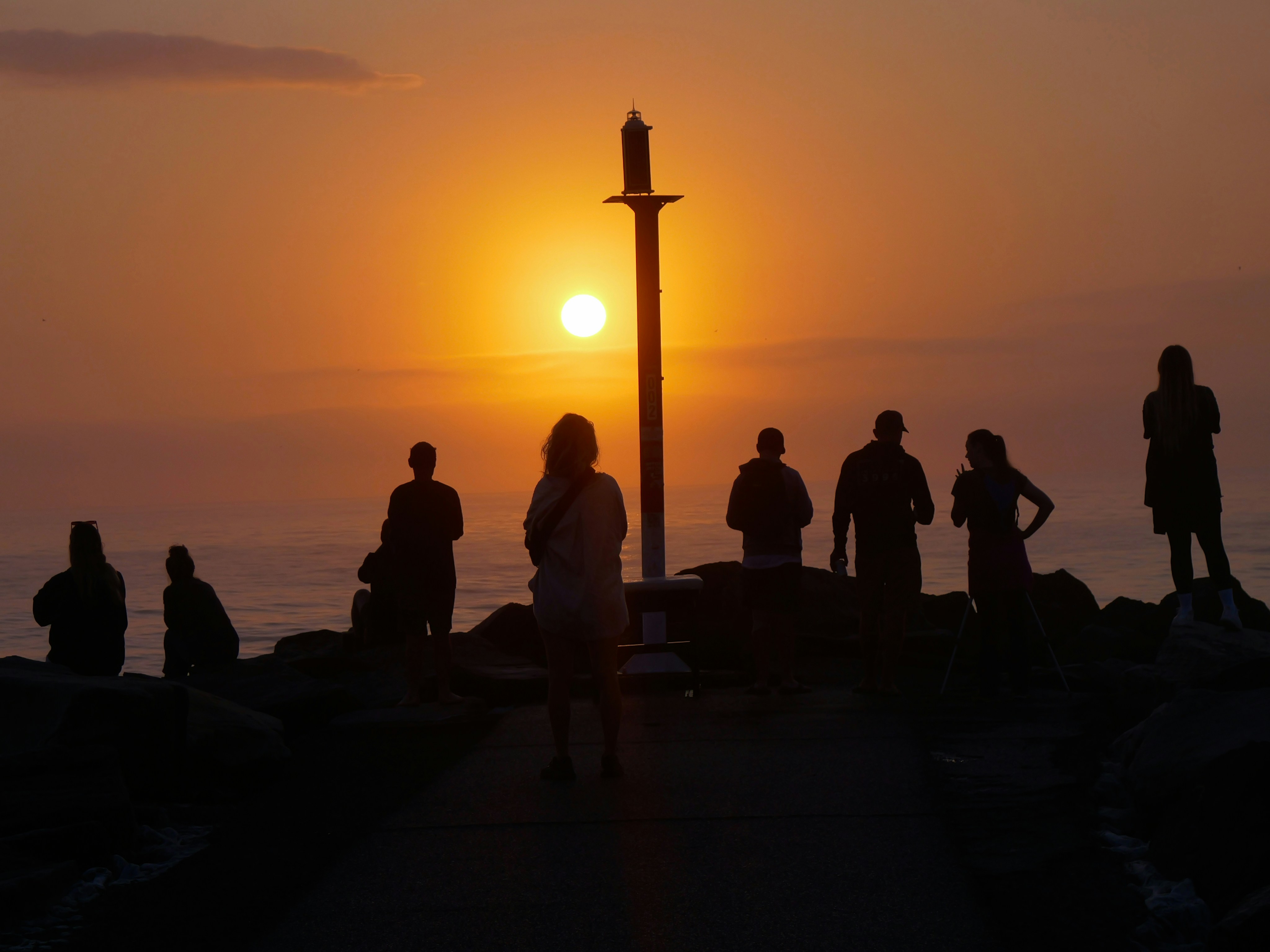 Silhouette Along the Dusk Pier Facing the Sunset