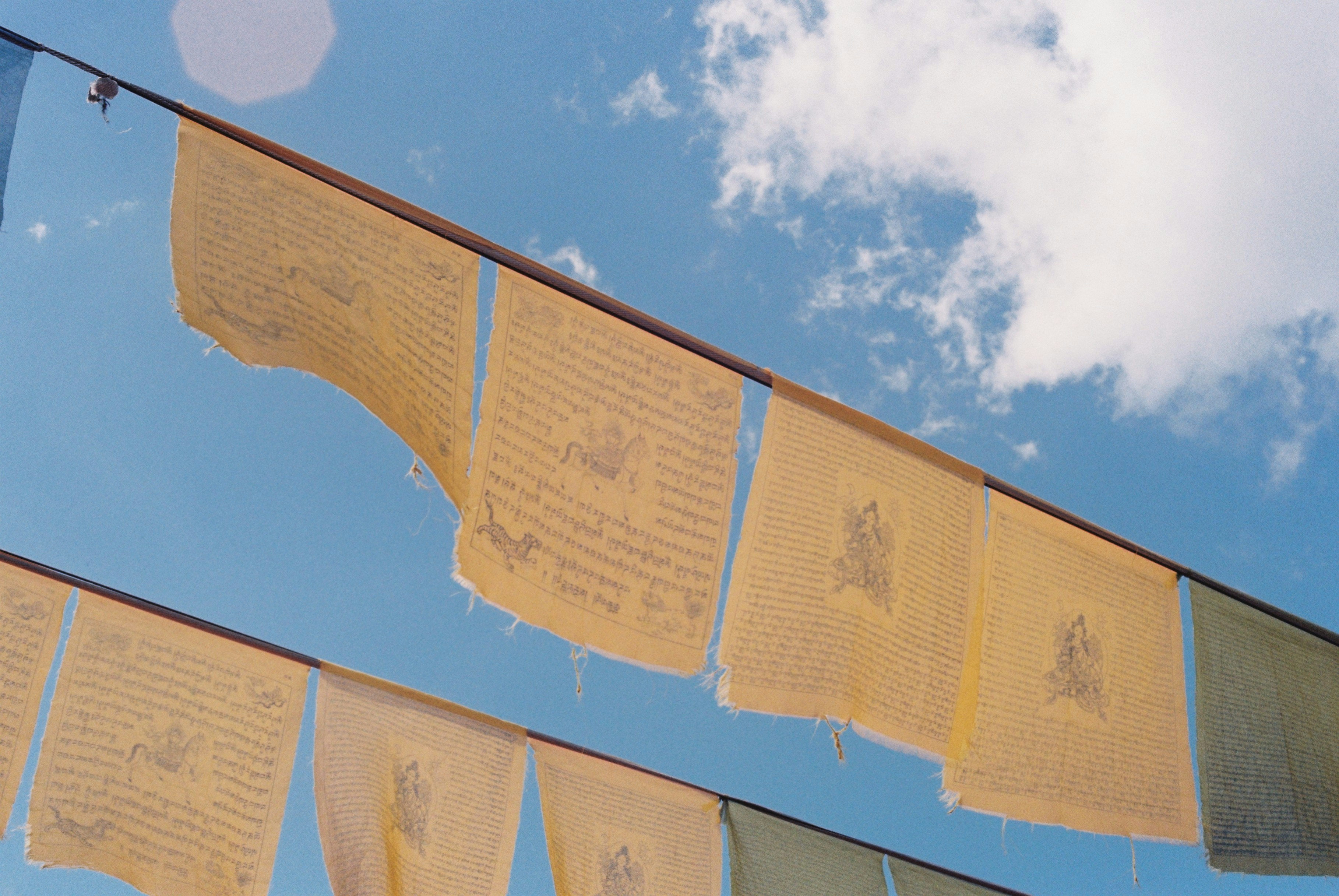 Flags in the Sky: Sunlit Prayer Papers on a Clear Day