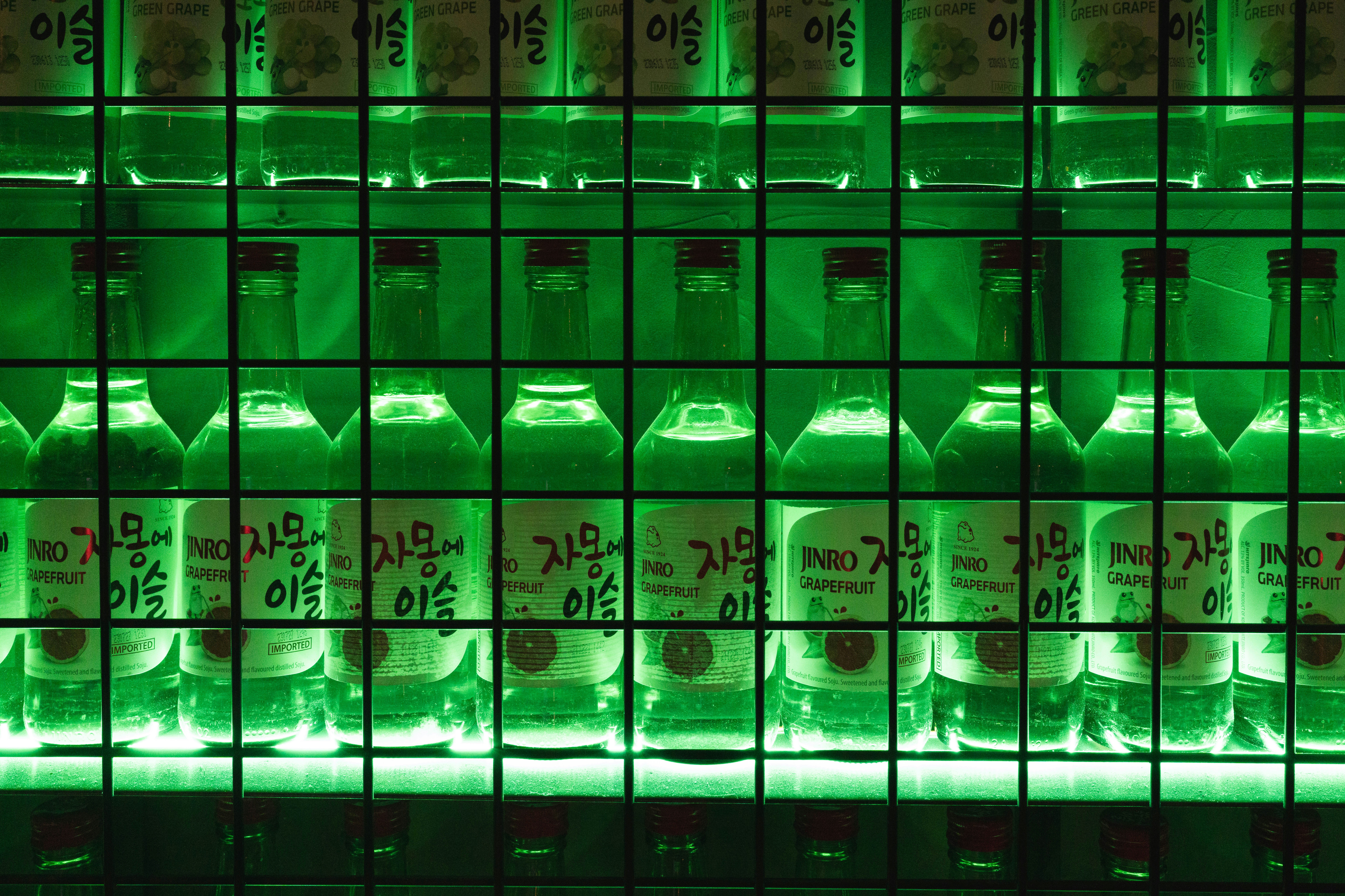 Neon-green Bottled Rows in a Backlit Refrigerator Grid