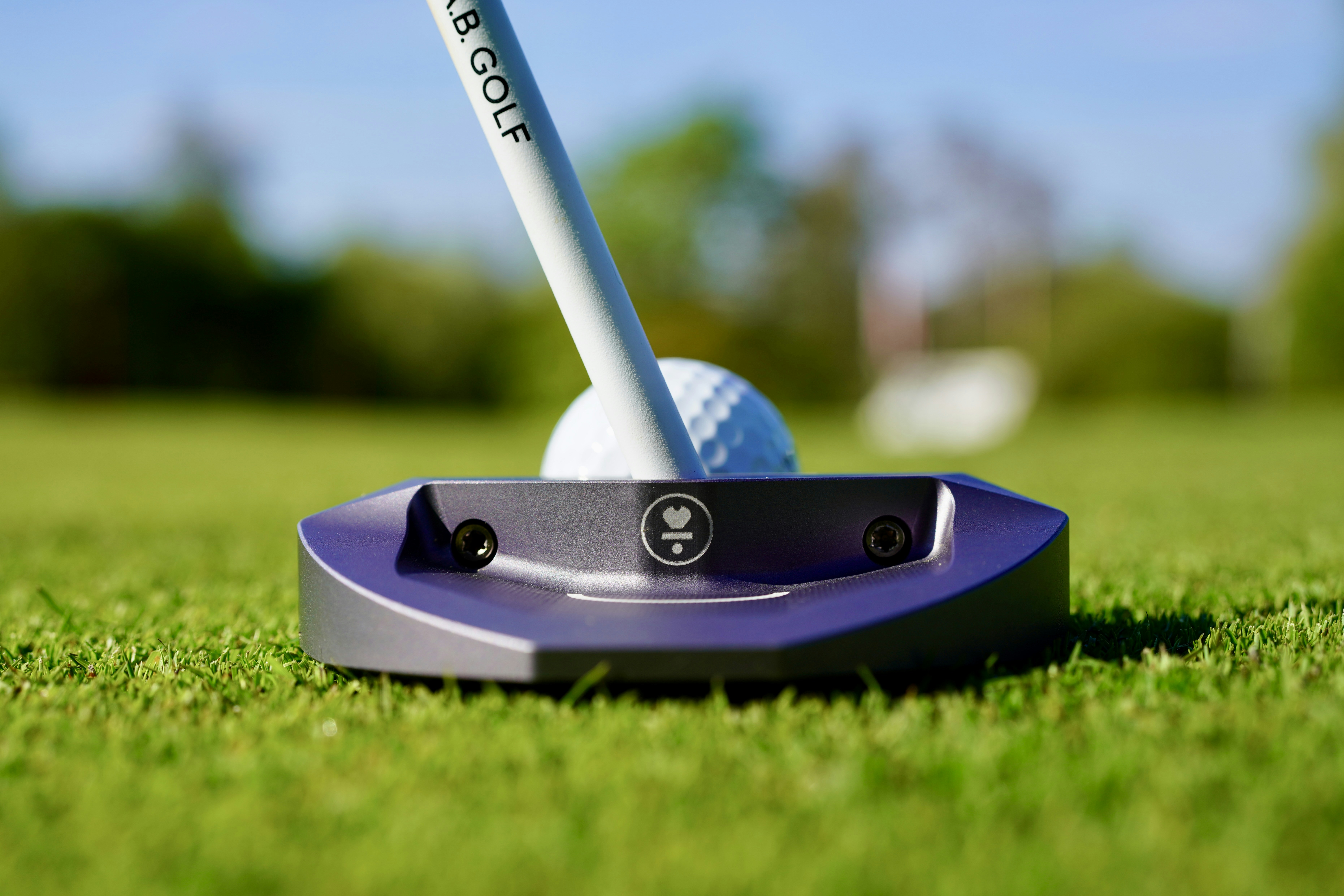 Close-up in the Green: The Putters’ Face and Ball at Sunrise