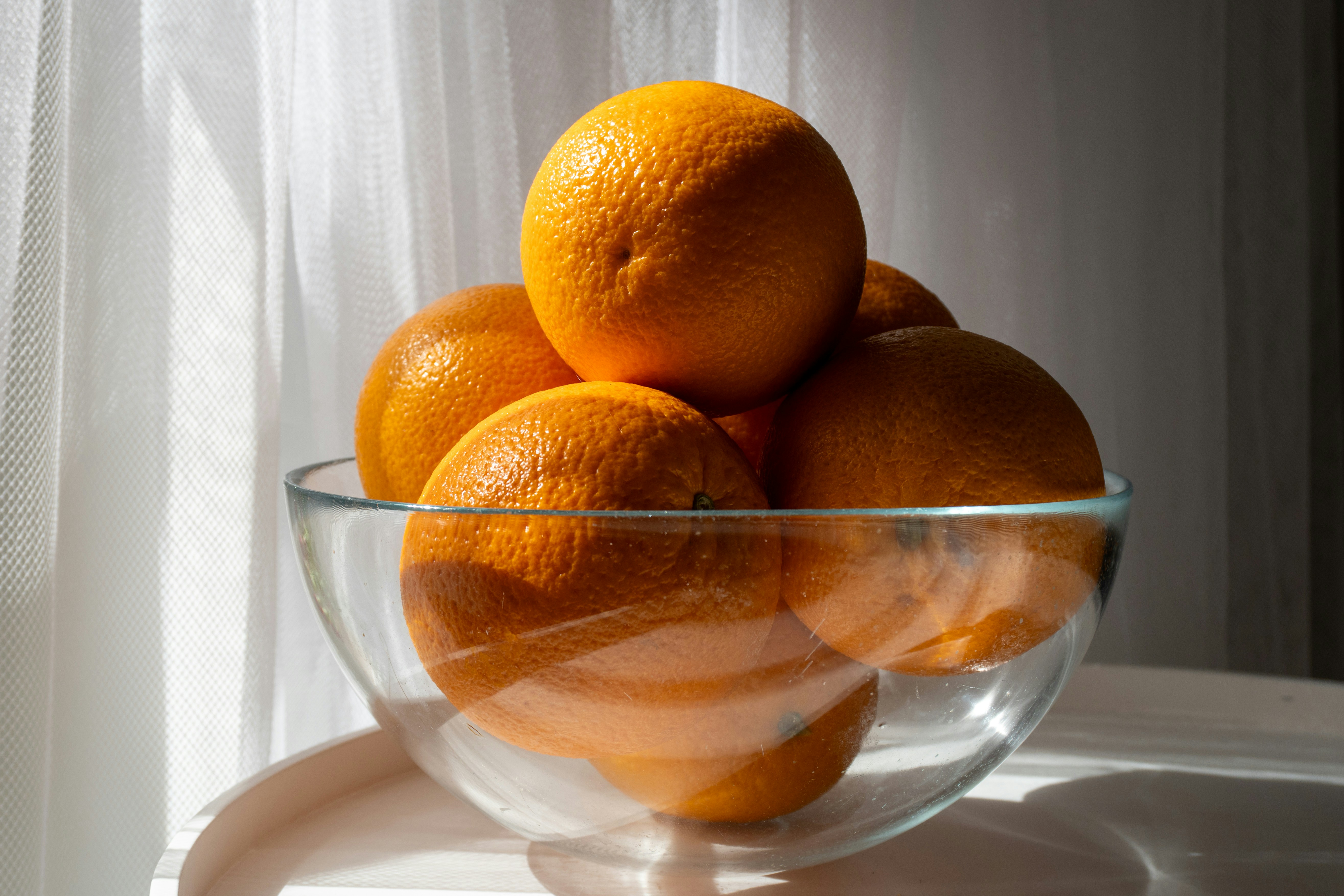 Citrus in Glass: Sunlit Oranges Weighing Light on a Quiet Table