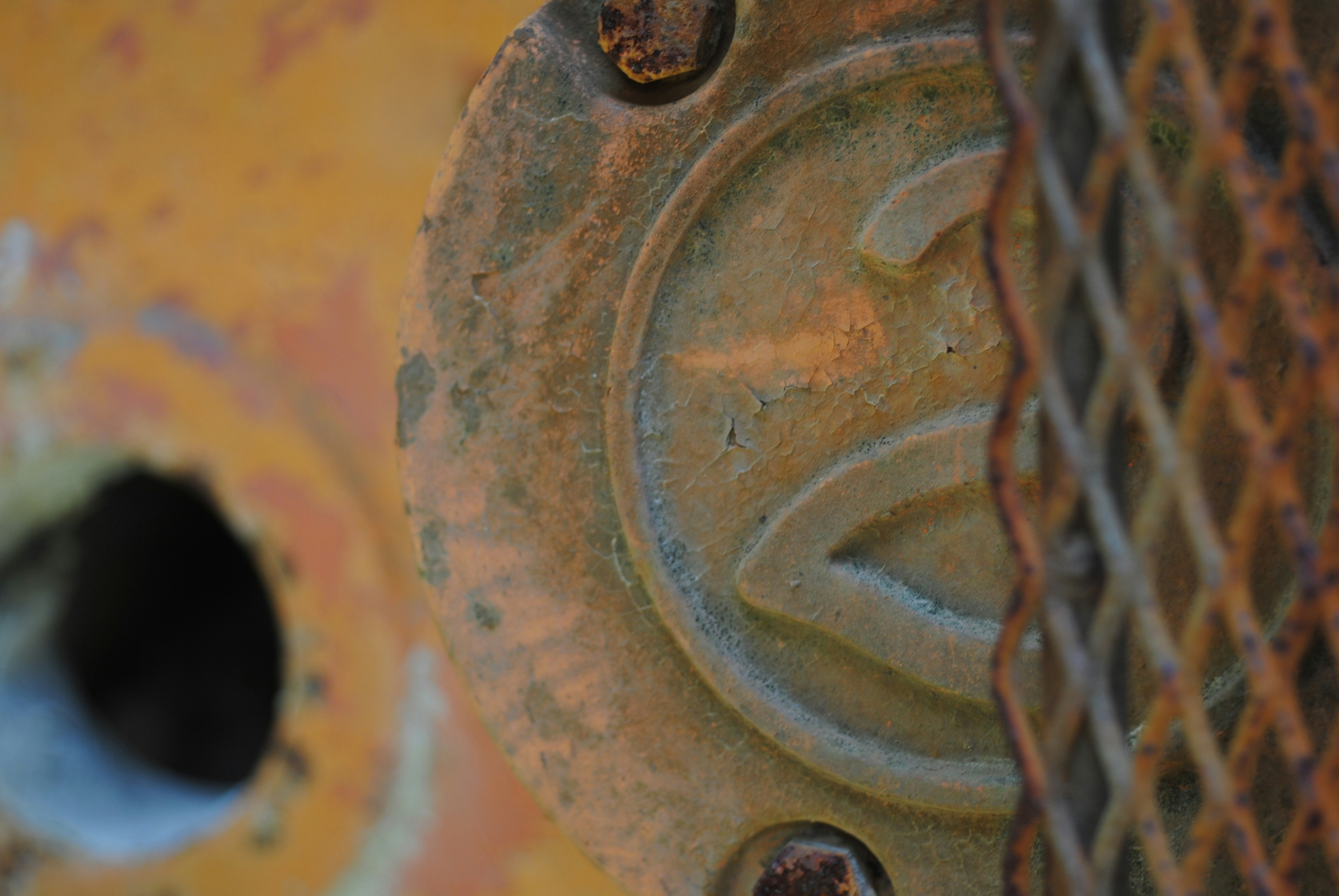 Rust and Grid: A Weathered Metal Disk Where Texture Meets Steel Mesh
