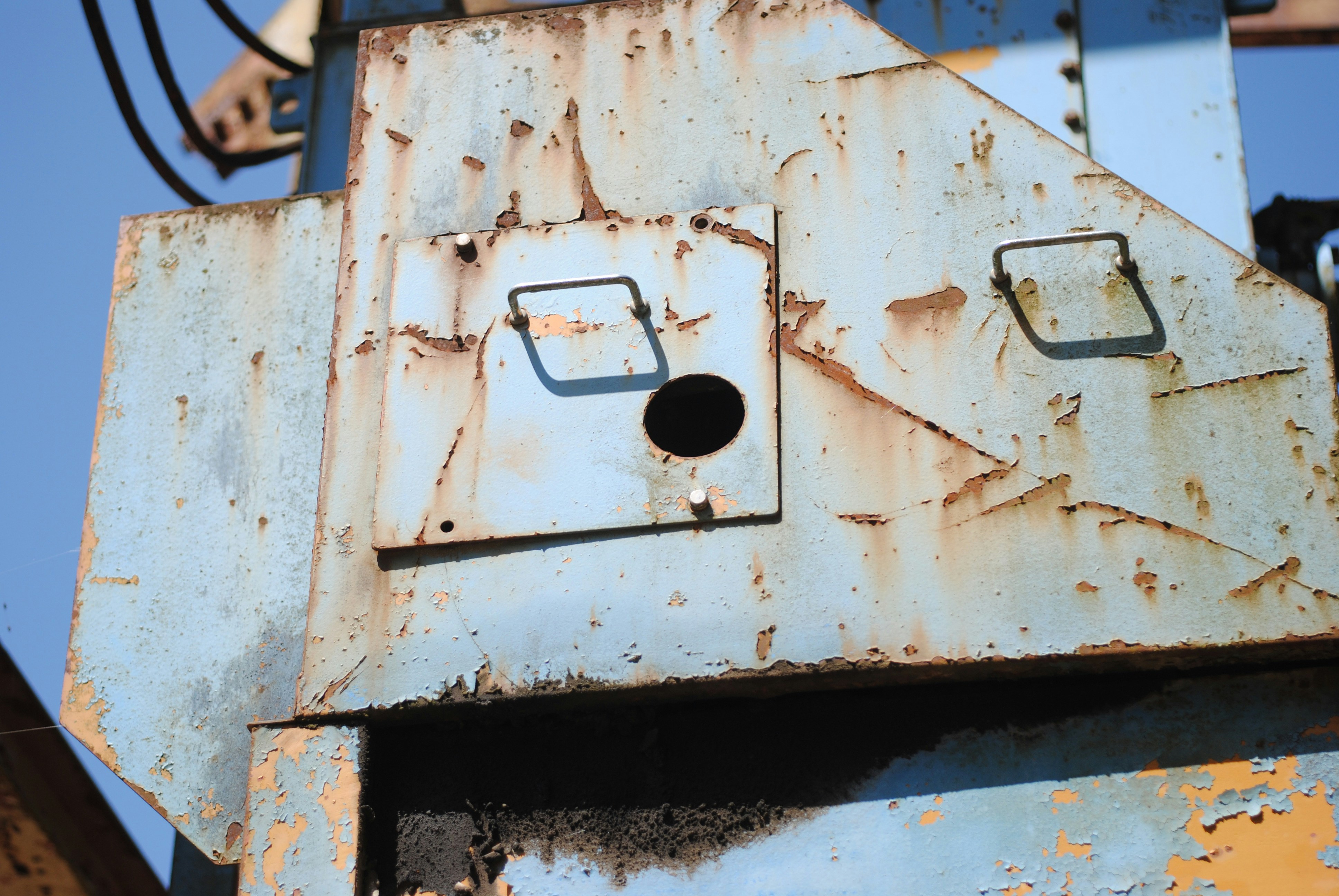 Rusted Geometry: A Weathered Steel Monolith Against a Clear Sky