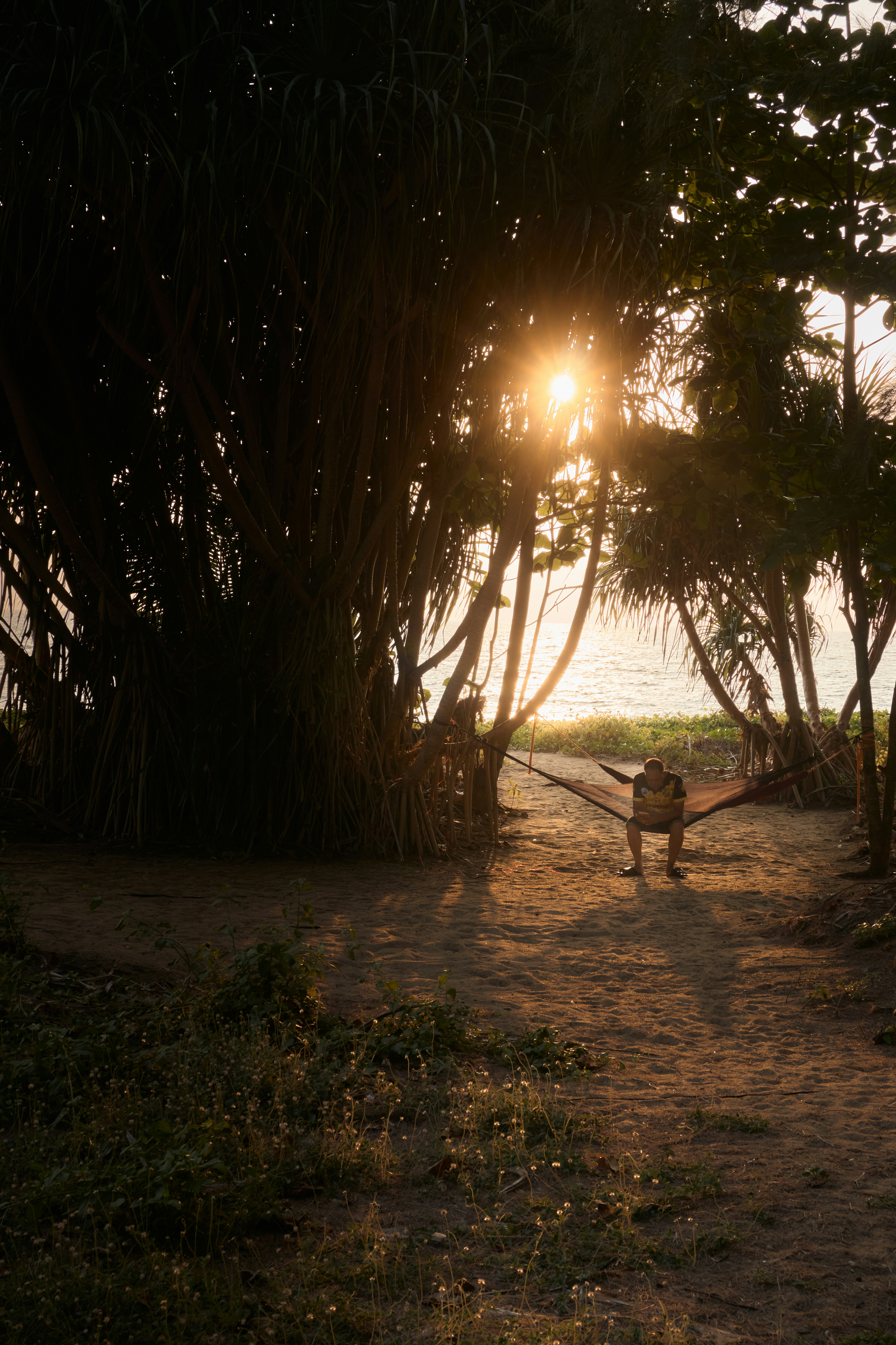 Hammocks at Dusk: Quiet Couple Resting Beneath Sunset Gate