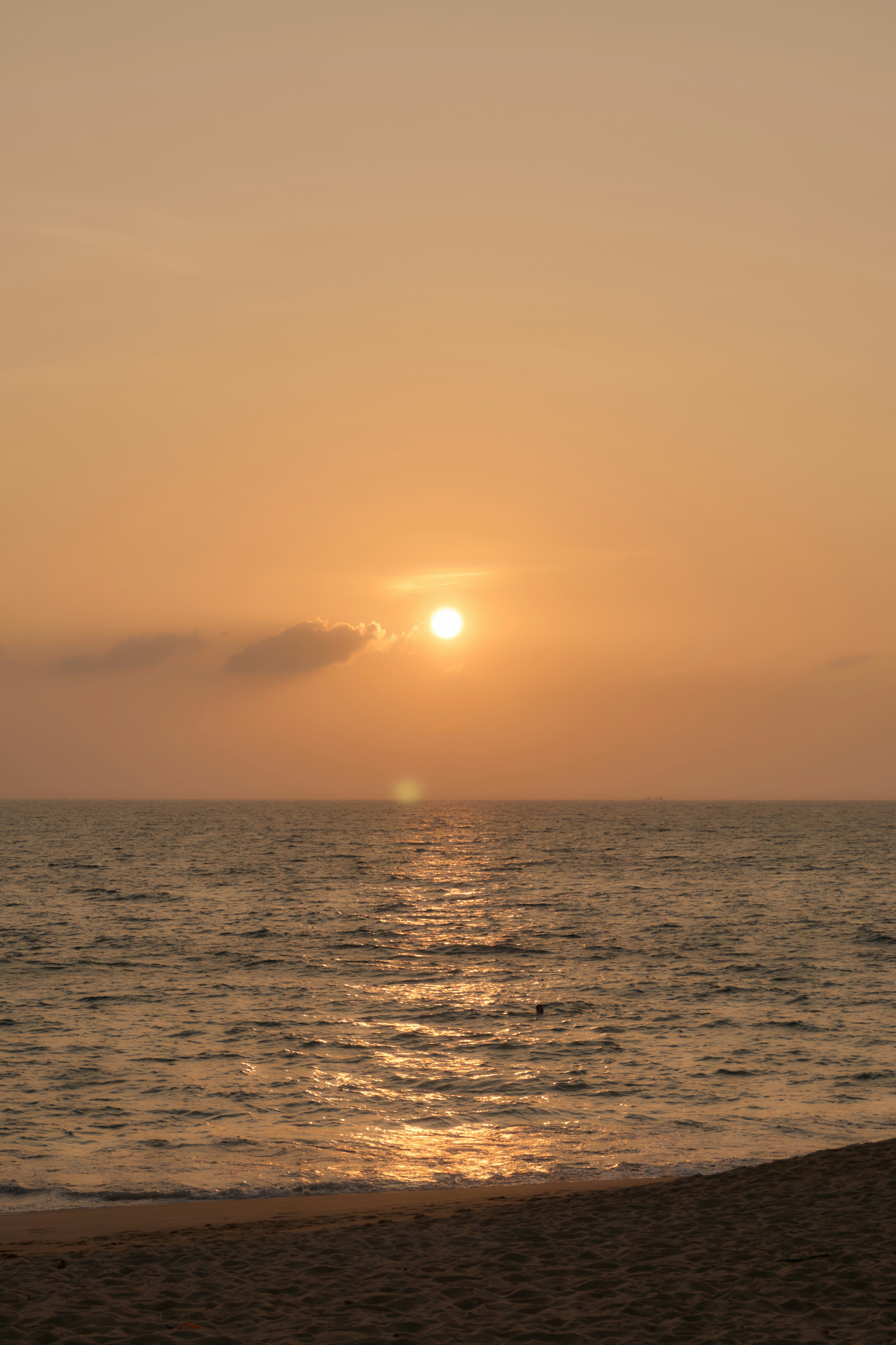 Sunlit Horizon: Solitary Orb Over Quiet Seas