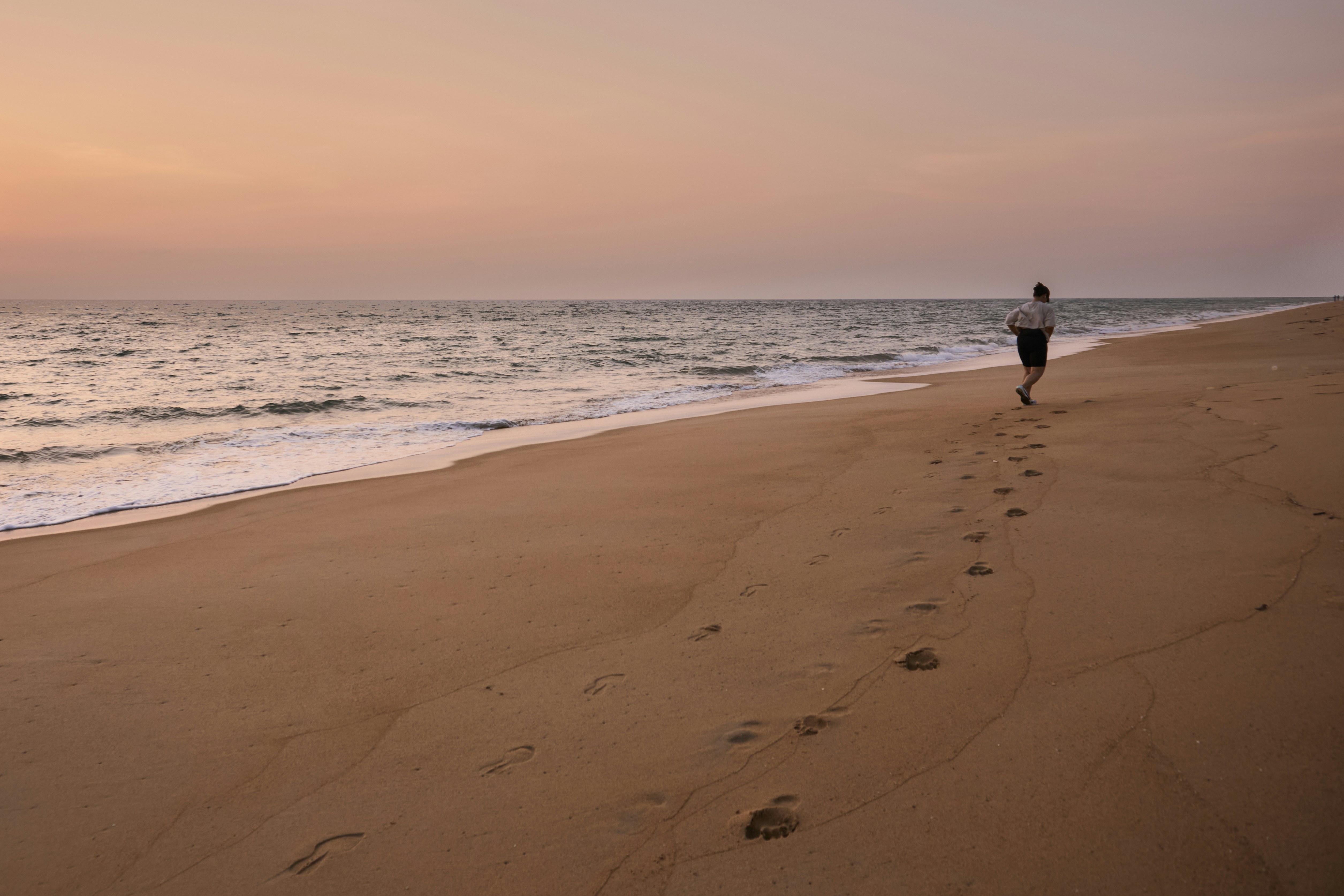 Solitary Runner at Dusk: A Quiet Shoreline Crossing