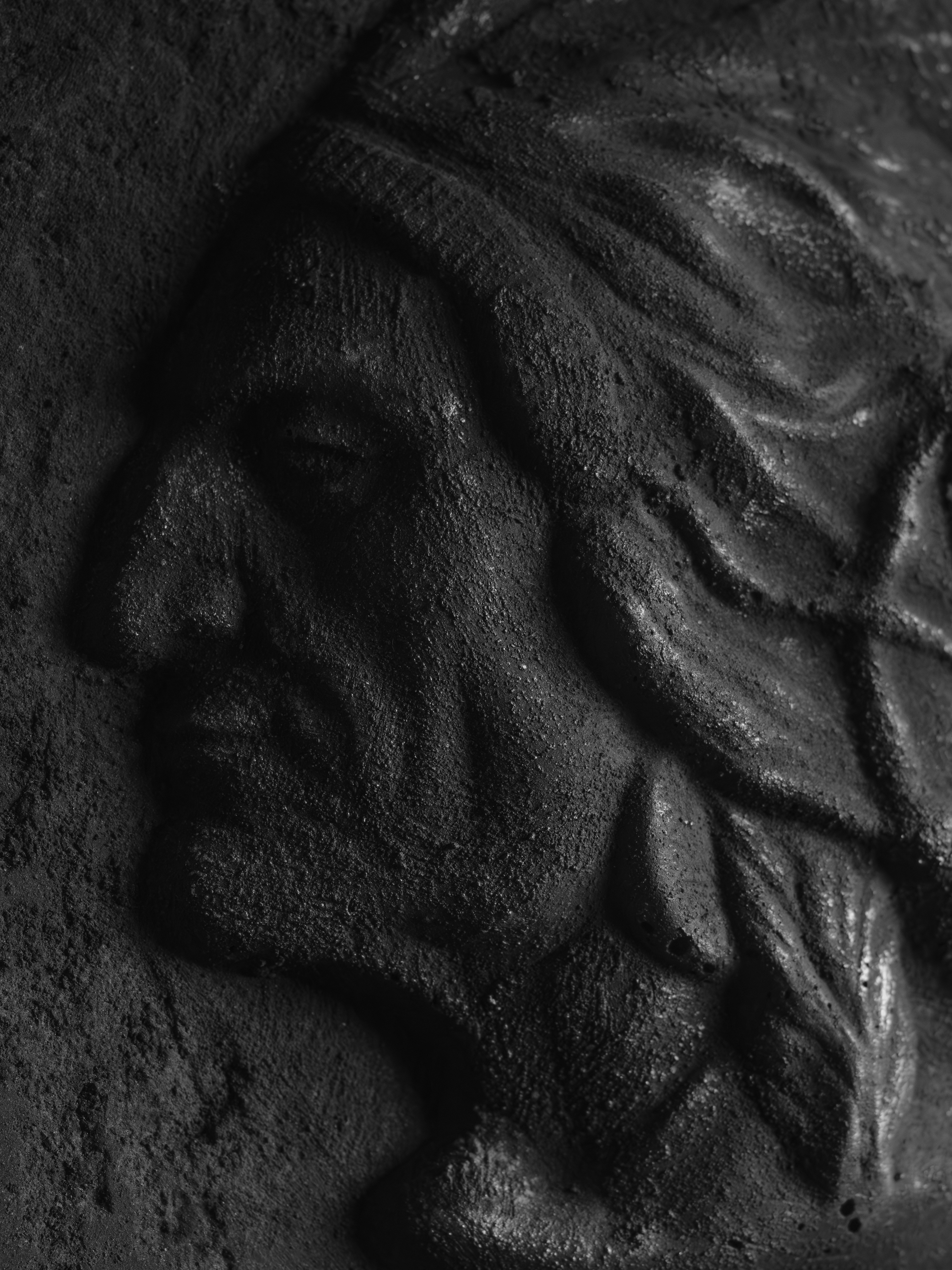 Darkened Stone Silhouette: A Grooved Bust in Shadow