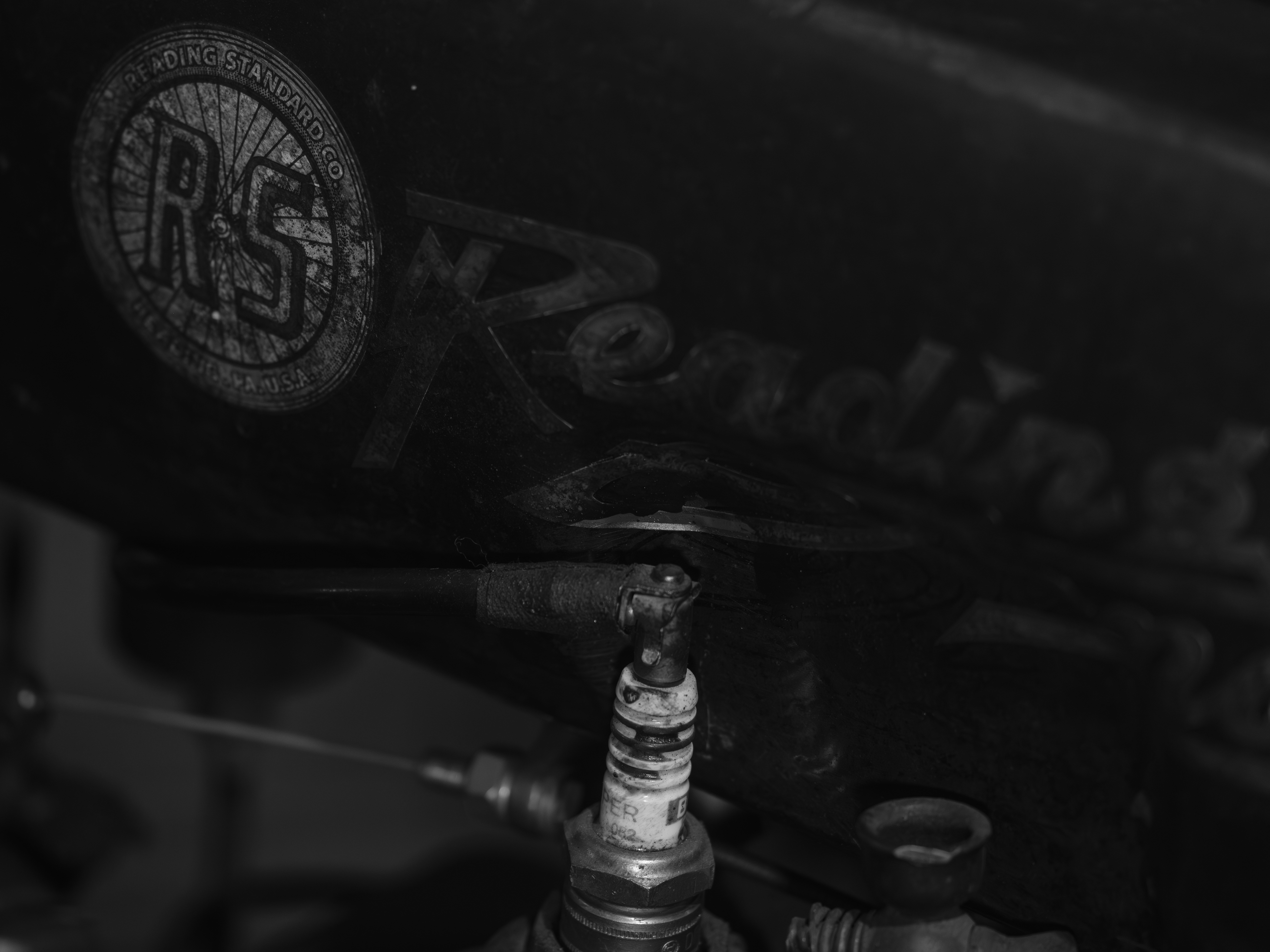 Rusted emblem and spark plug: a quiet moment of engine nostalgia