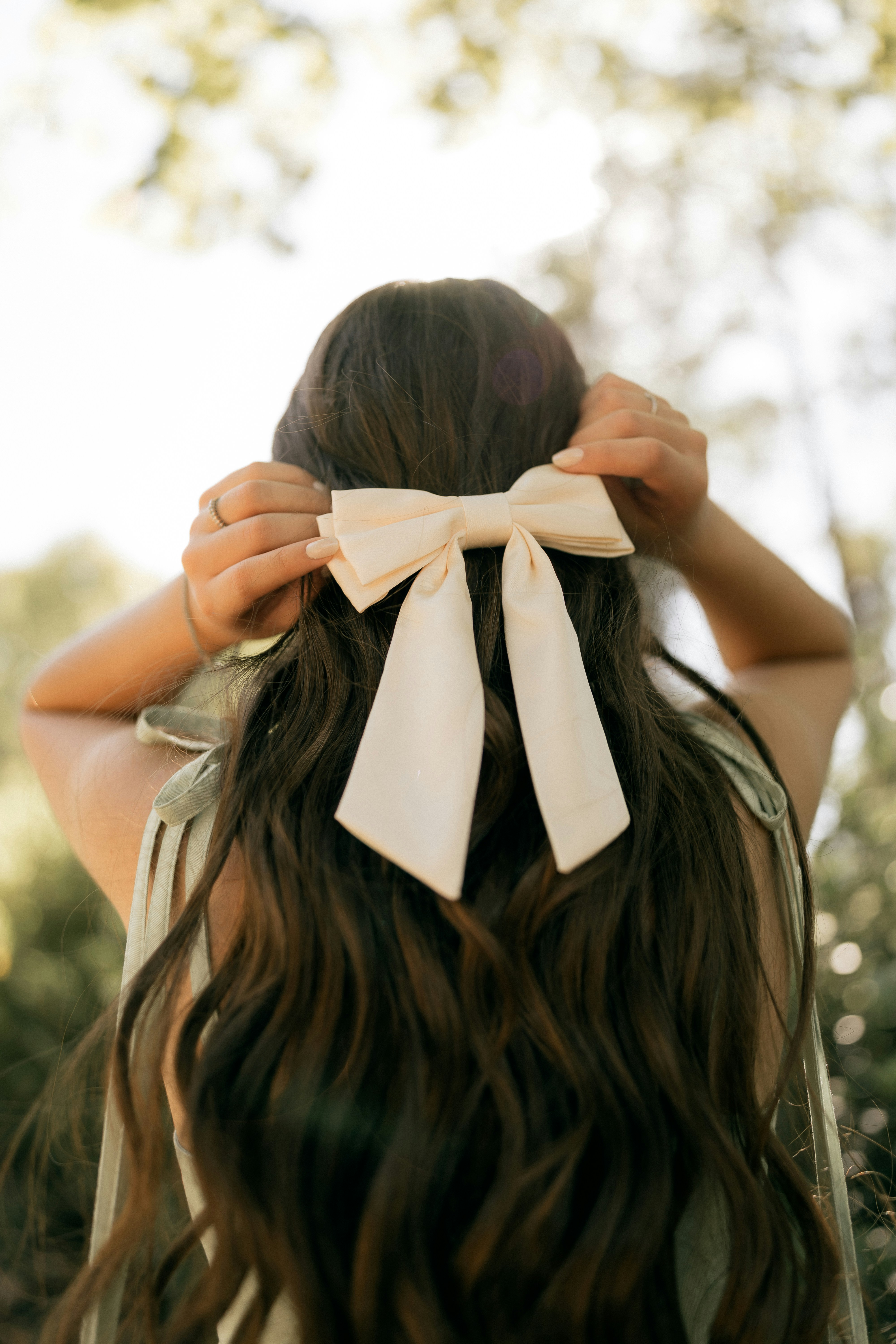 Backlit Ribbon: A Portrait of a Woman with a Cream Bow in Her Hair