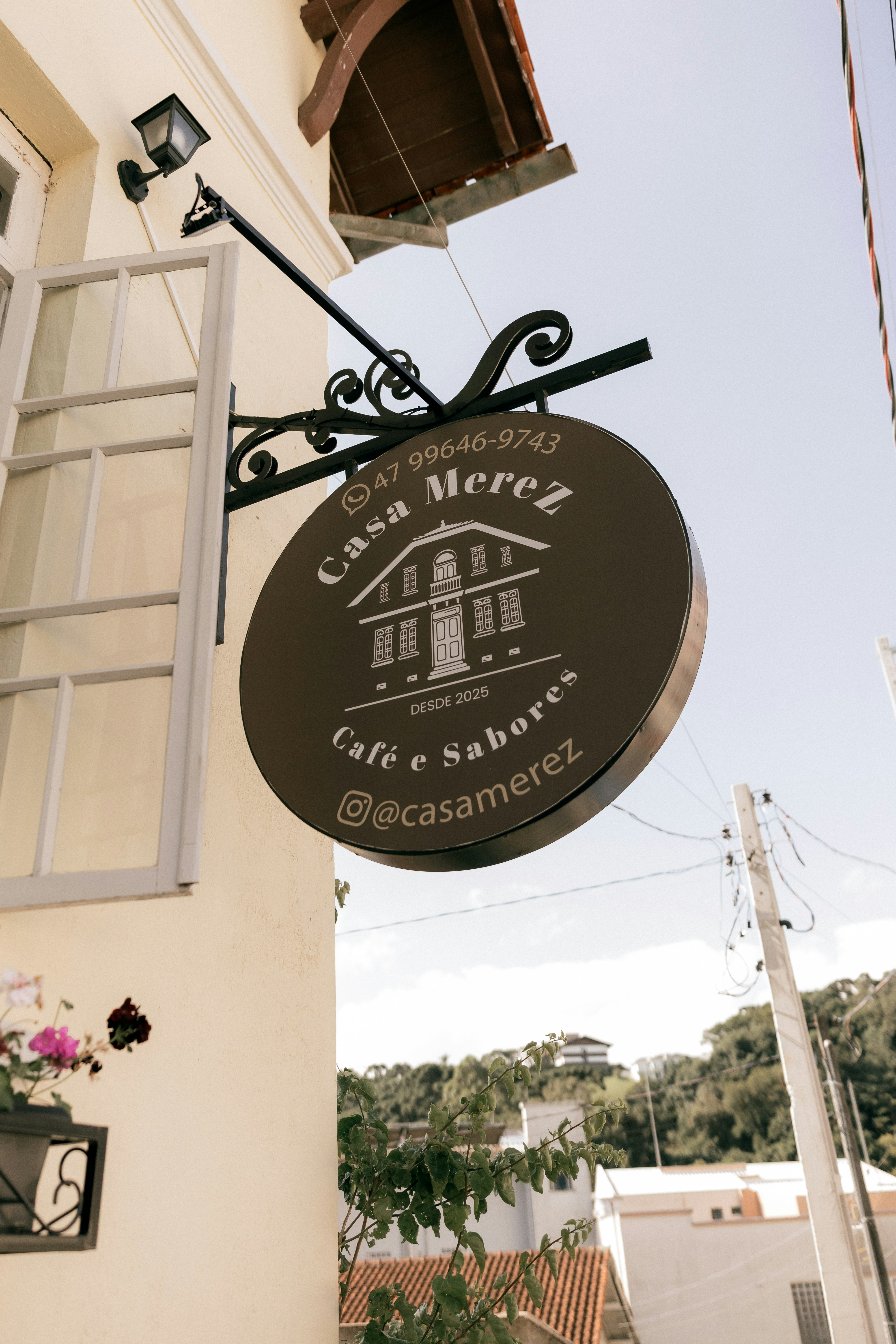 Circular Signboard of Casa Meraz Café in Soft Sunlit Street