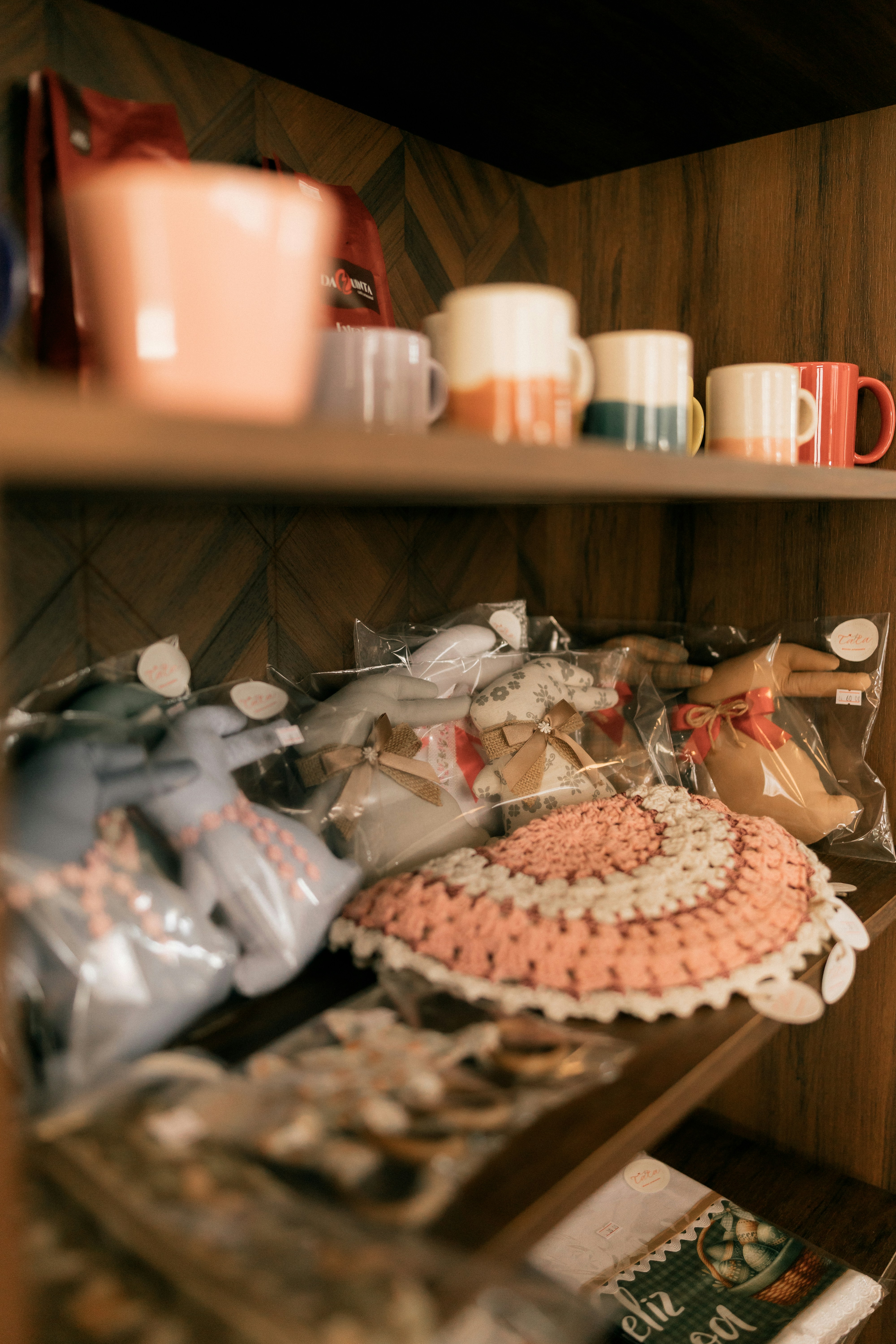 Ceramic Mugs and Crochet Doilies on a Wooden Shelf