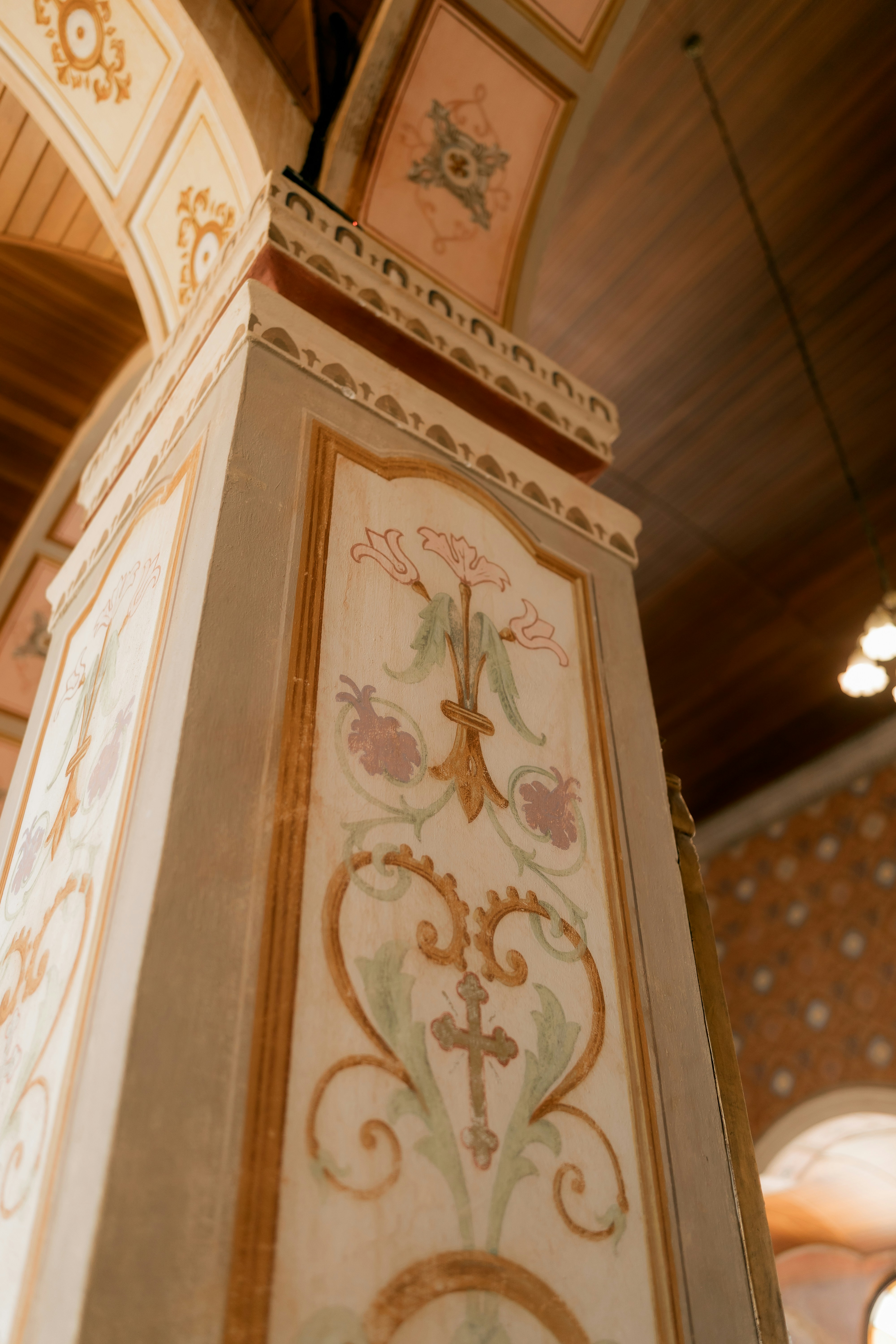 Ornate column frescoes inside a warm-hued hall