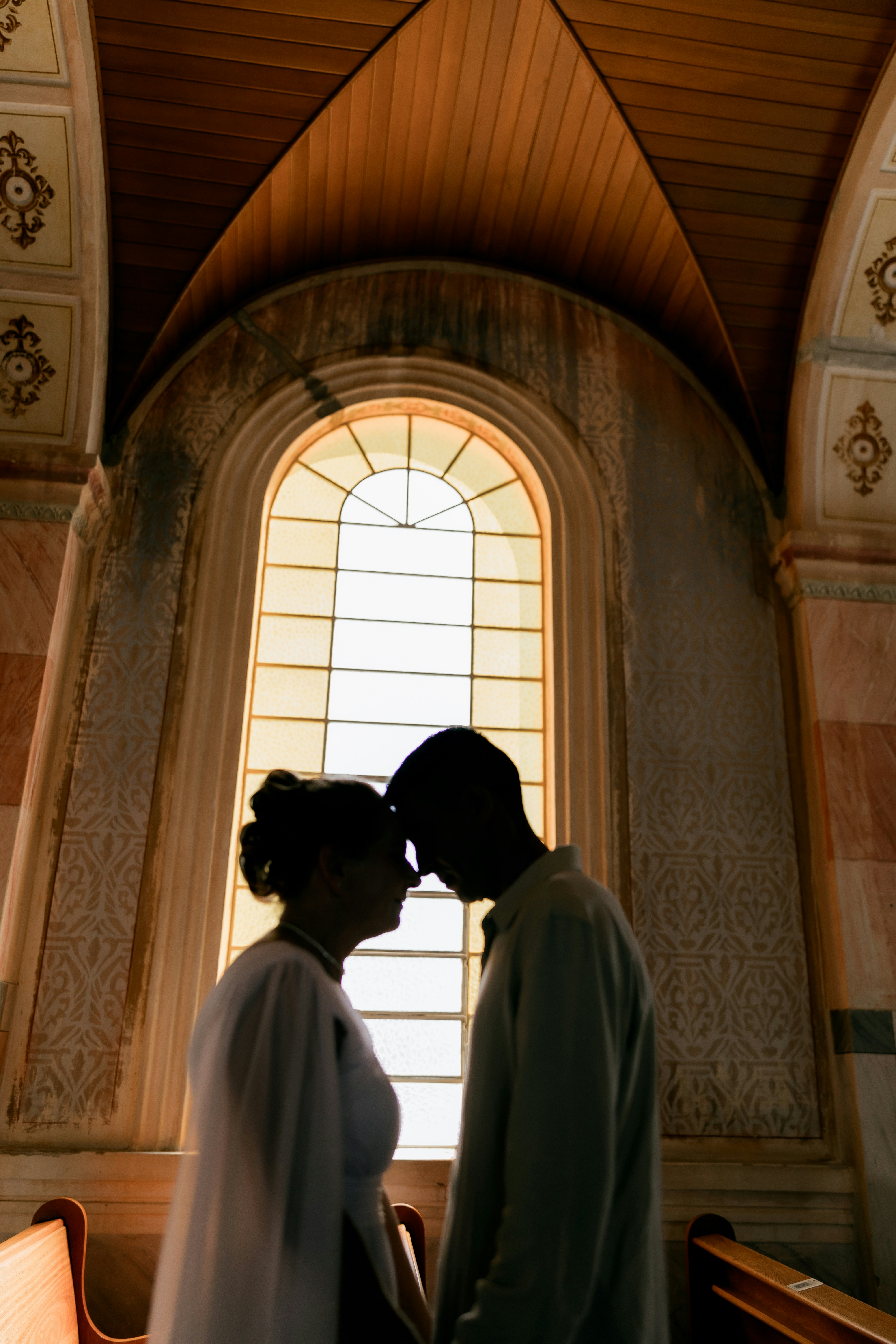 Silhouette in the Chapel: A Quiet Moment Beneath the Arch Window