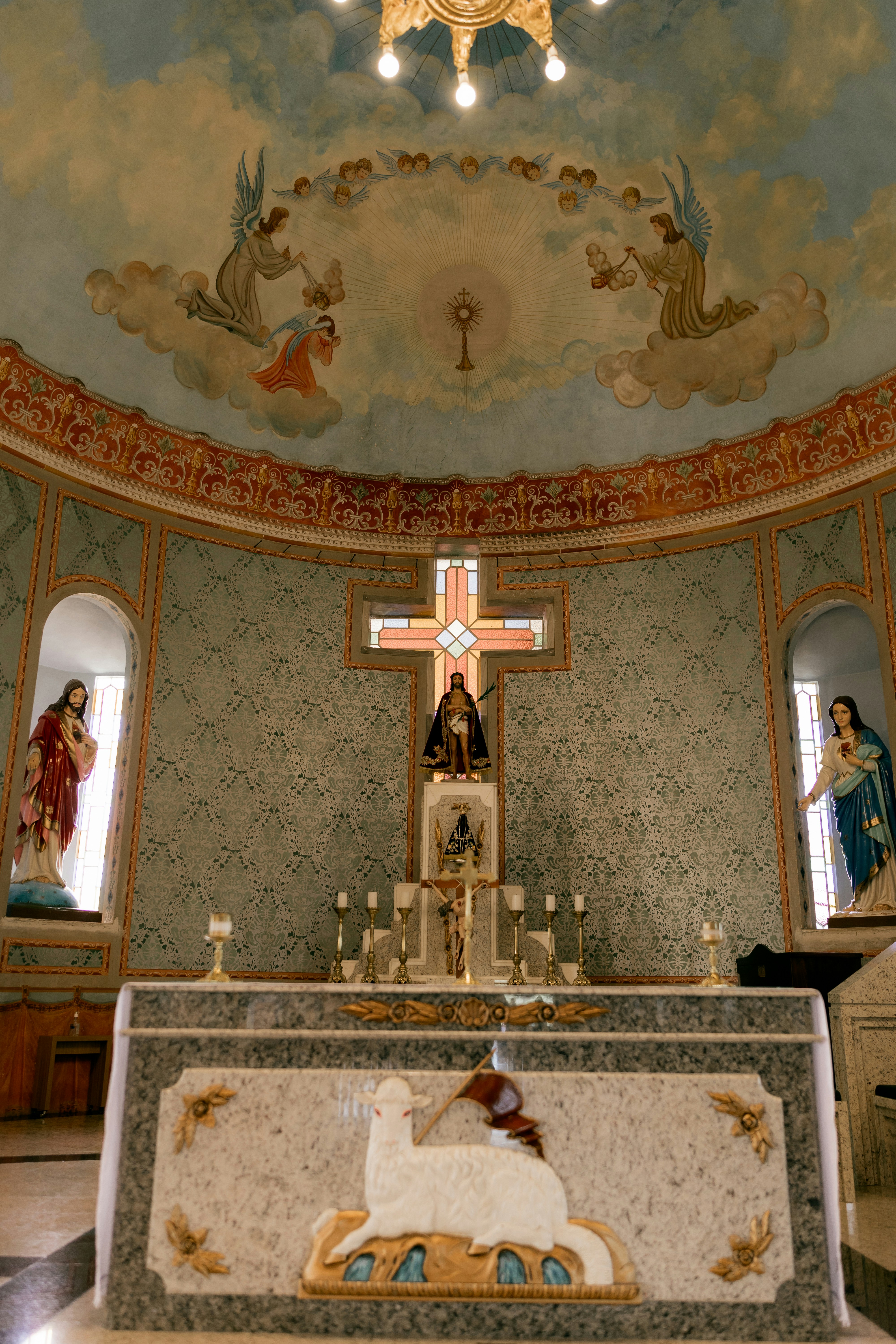 Saintly Illumination: Central Cruciform Window Framing the Altar
