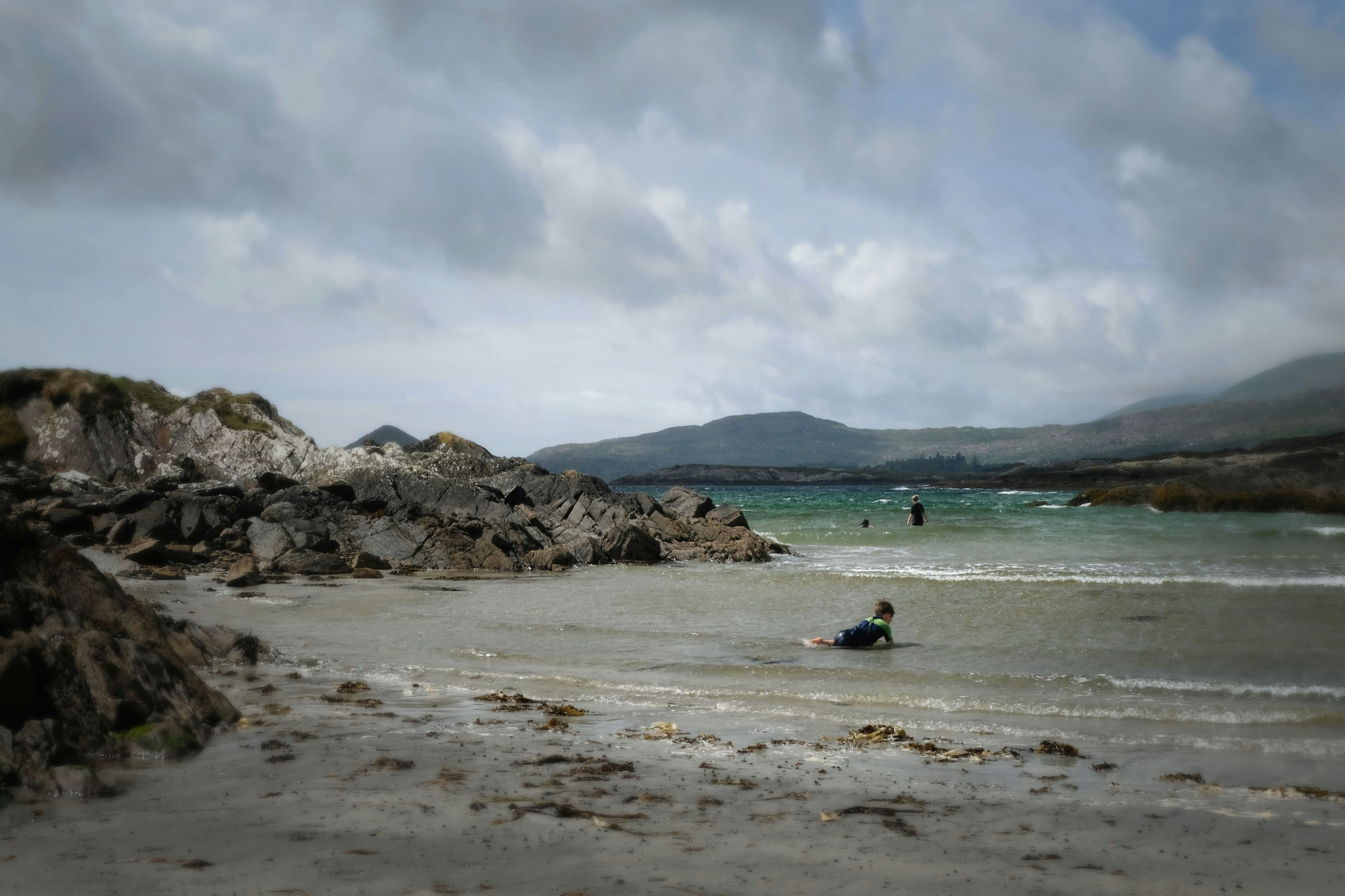 Toward the Quiet Edge: Surfer and Rockscape at Distant Shore
