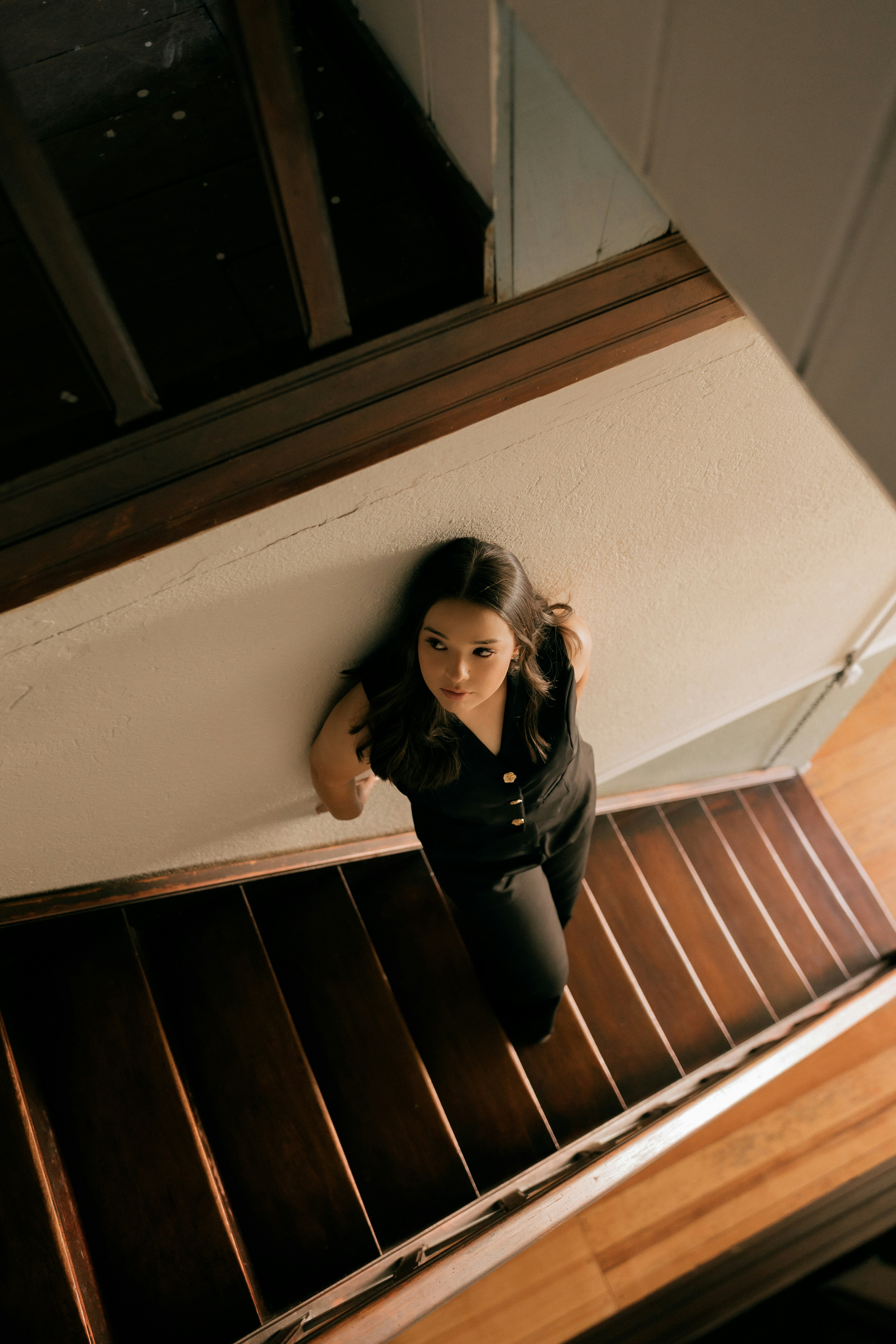 Aerial Stairwell Portrait: Woman in Black on a Winding Flight