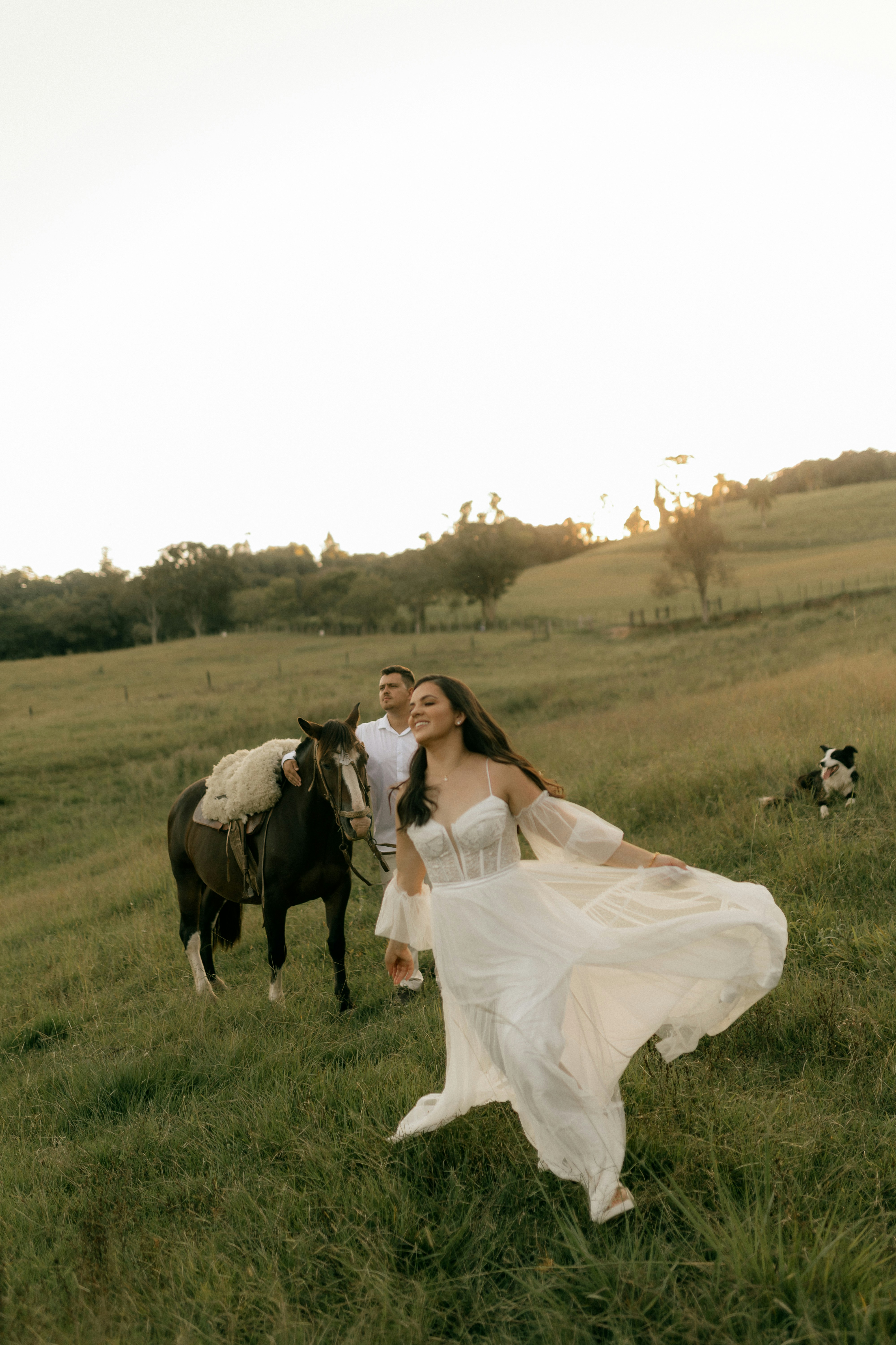 Bride in White Amid Rolling Hills with Pony and Dog