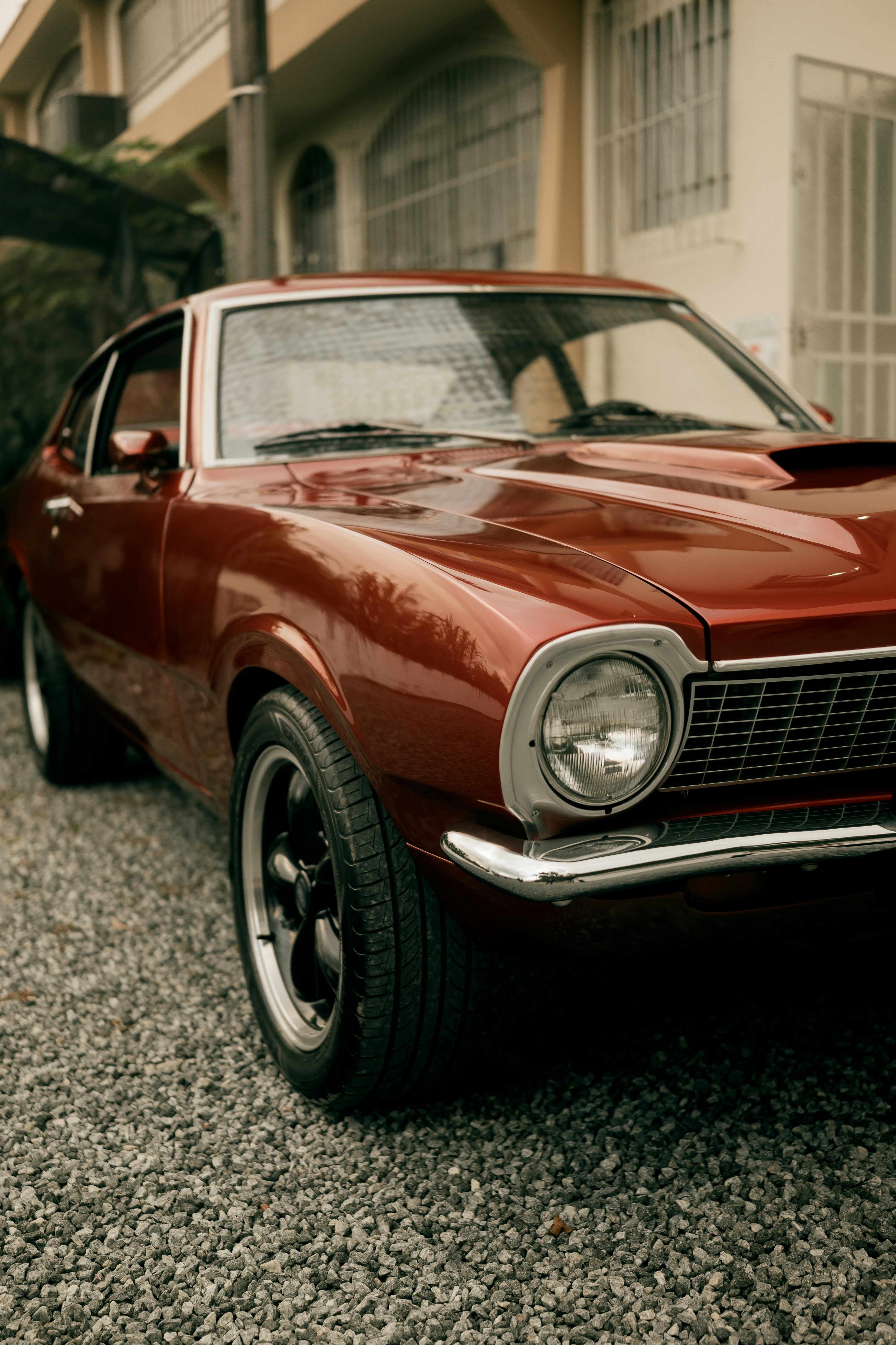 Crimson Vintage: A Classic Car Resting on Pebble Quiet