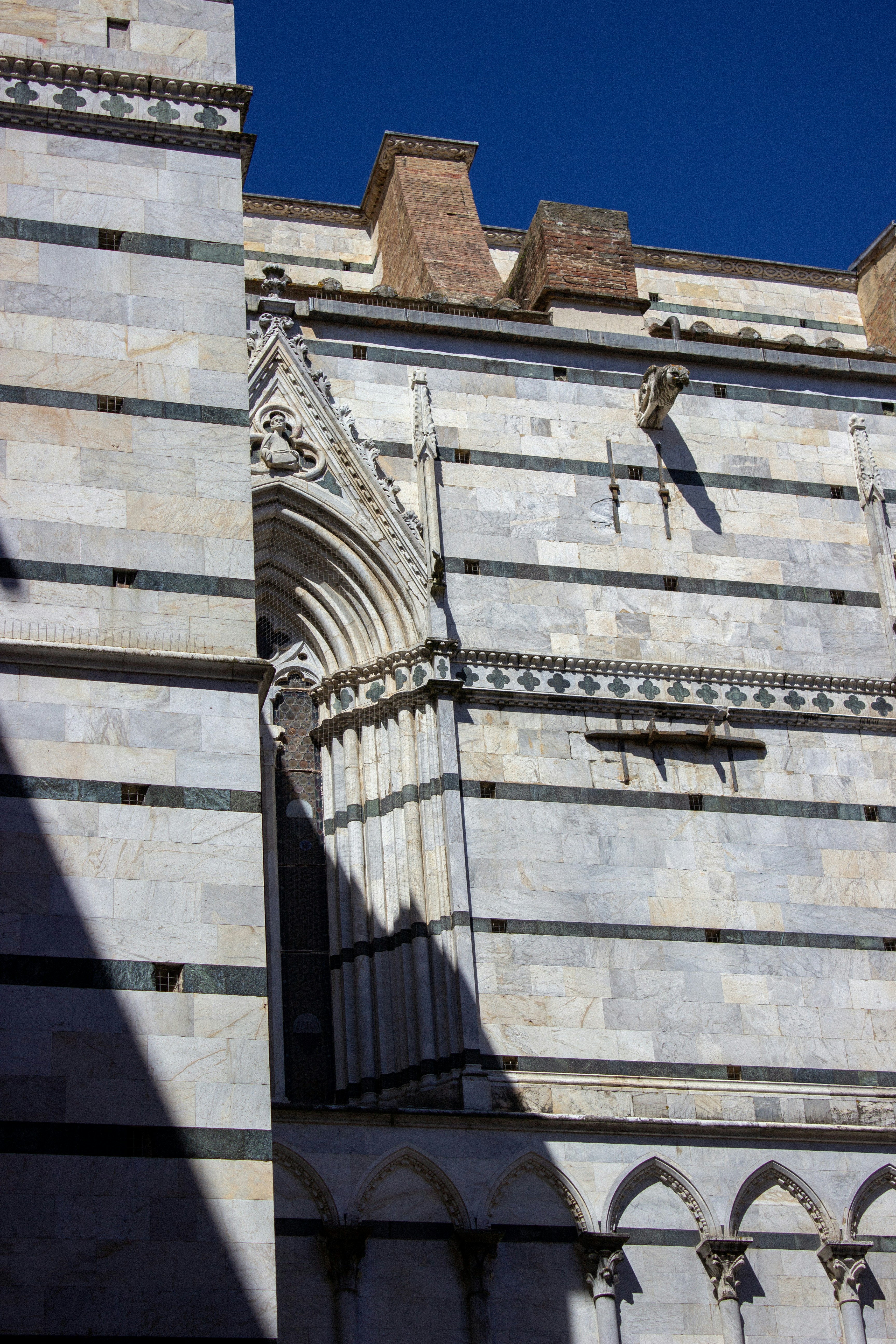 Stone Facade of a Gothic Revival Structure Under Clear Blue Sky