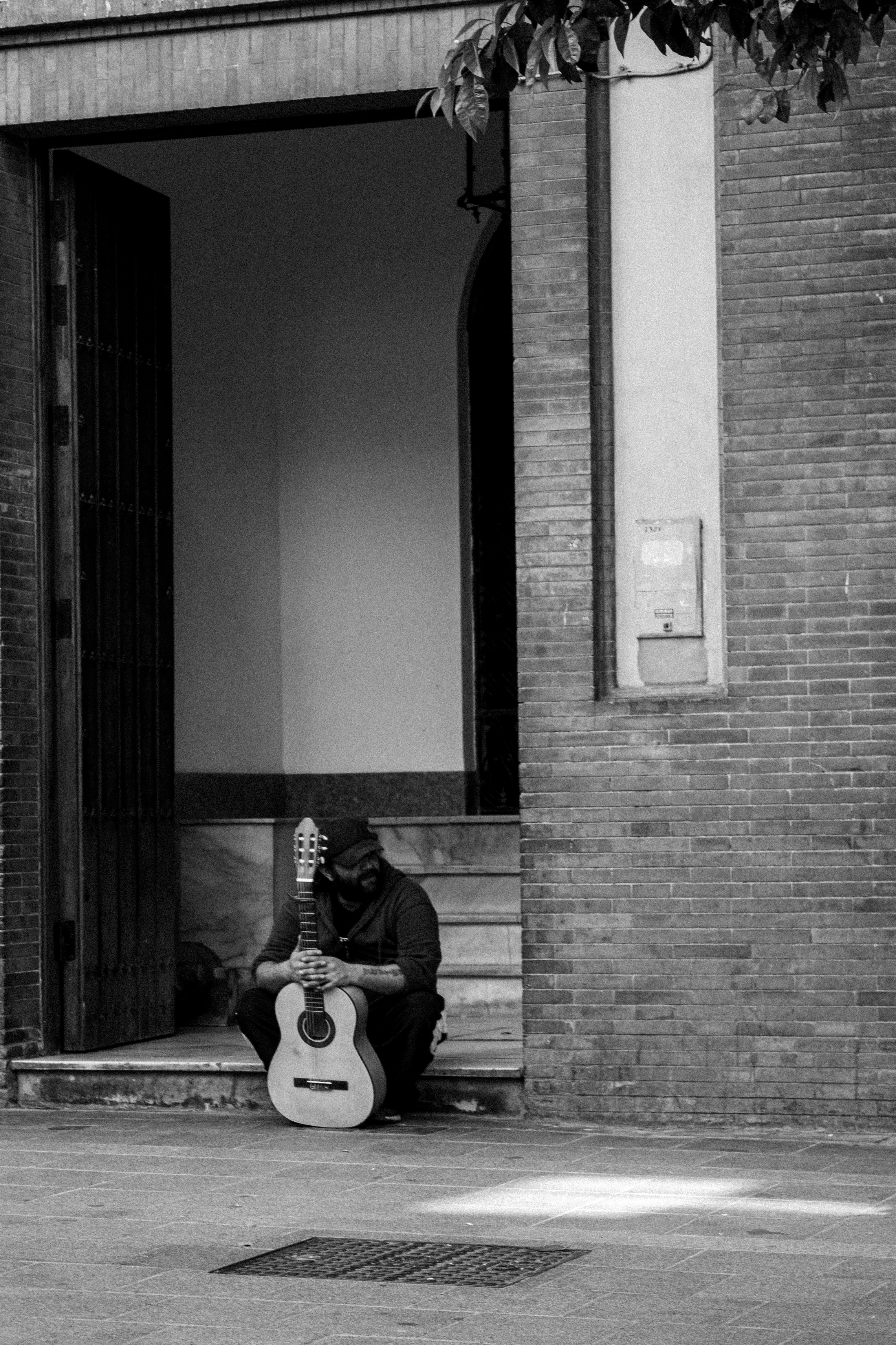Guitarist in the Quiet Threshold of a Brick Archway
