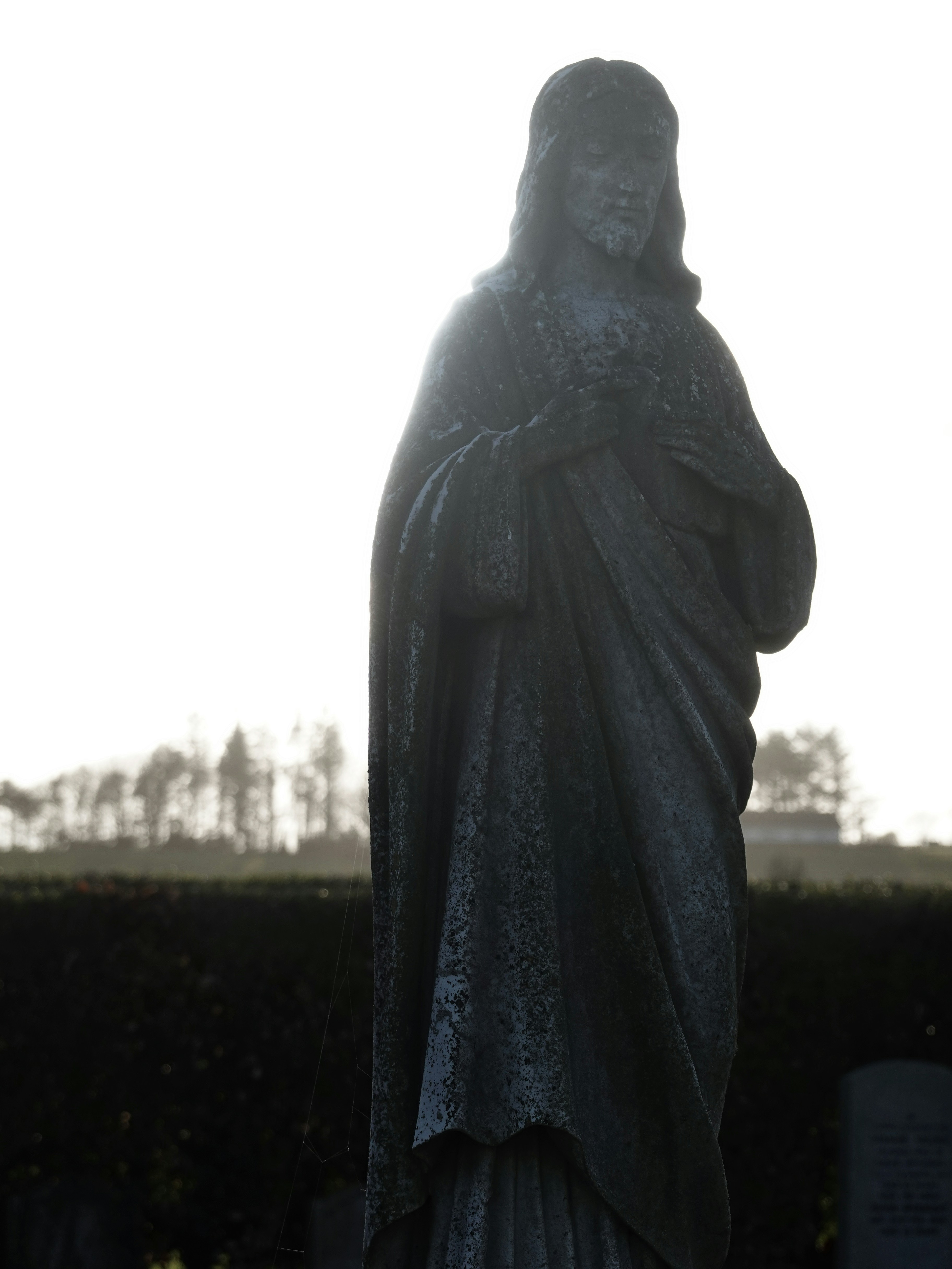 Statue in Silhouette: Quiet Reverence against a Bright Horizon
