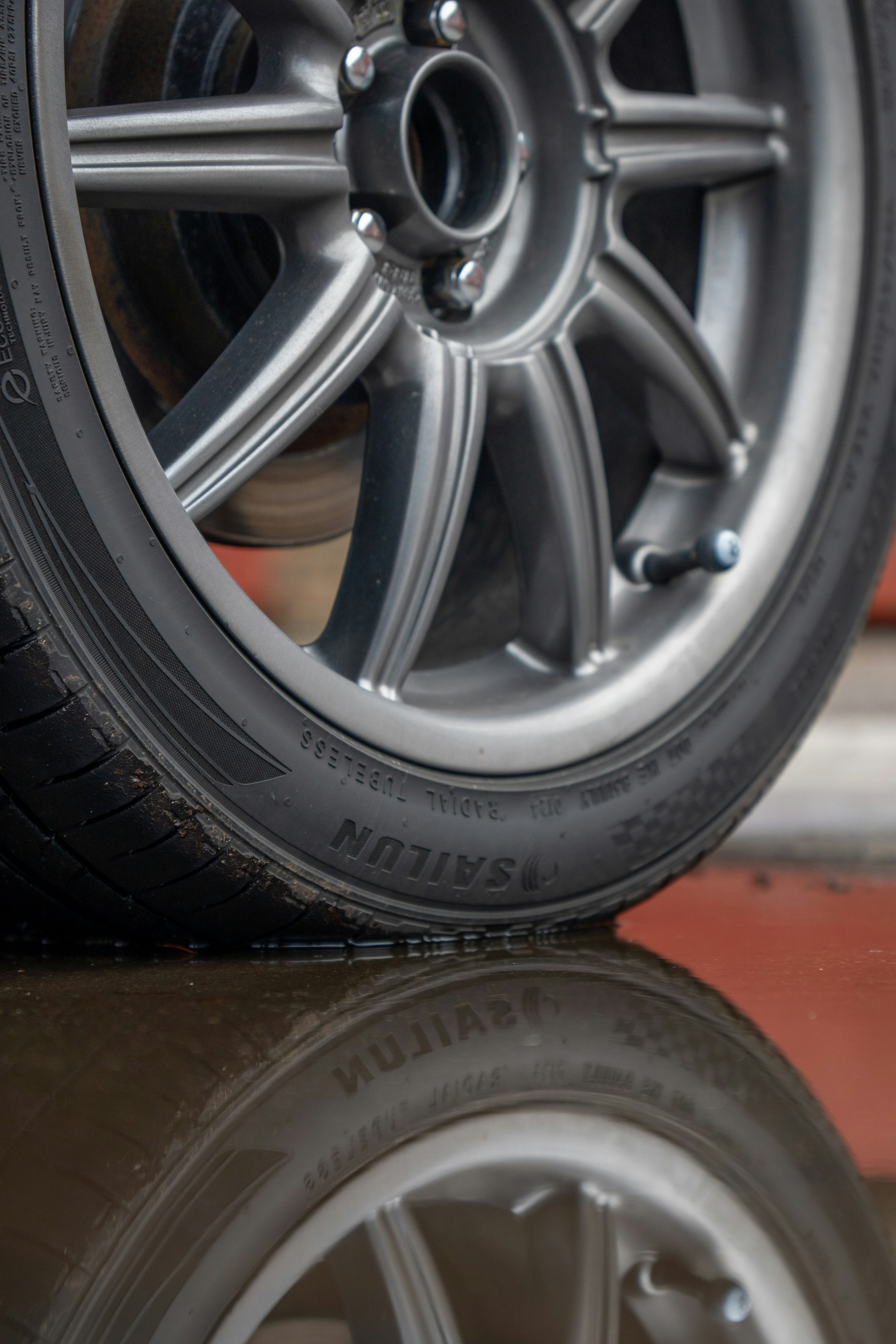 Close-Up of a Car Wheel and Reflected Tire
