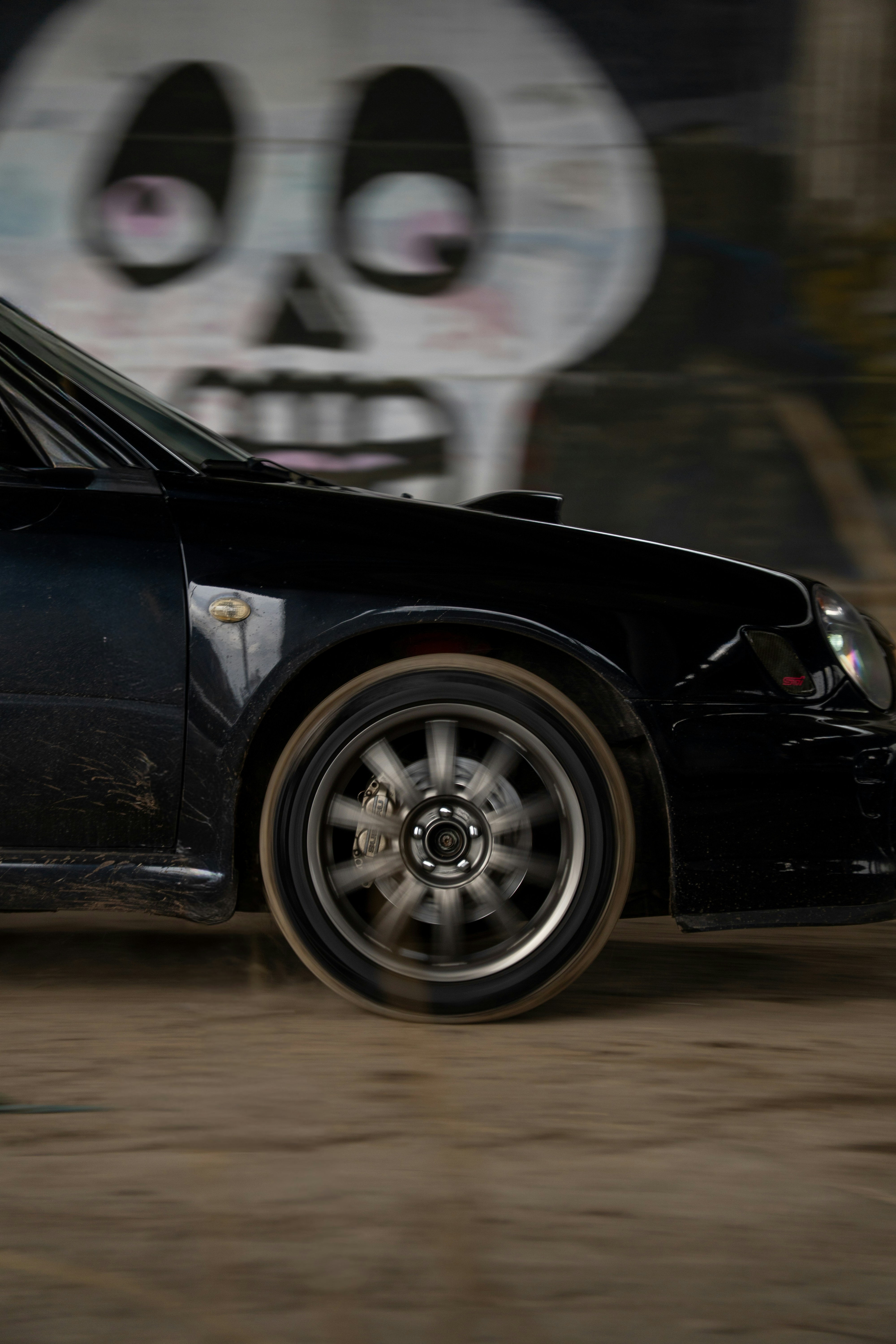 Low-Ridgetro Car in Motion Past a Graffiti Skull