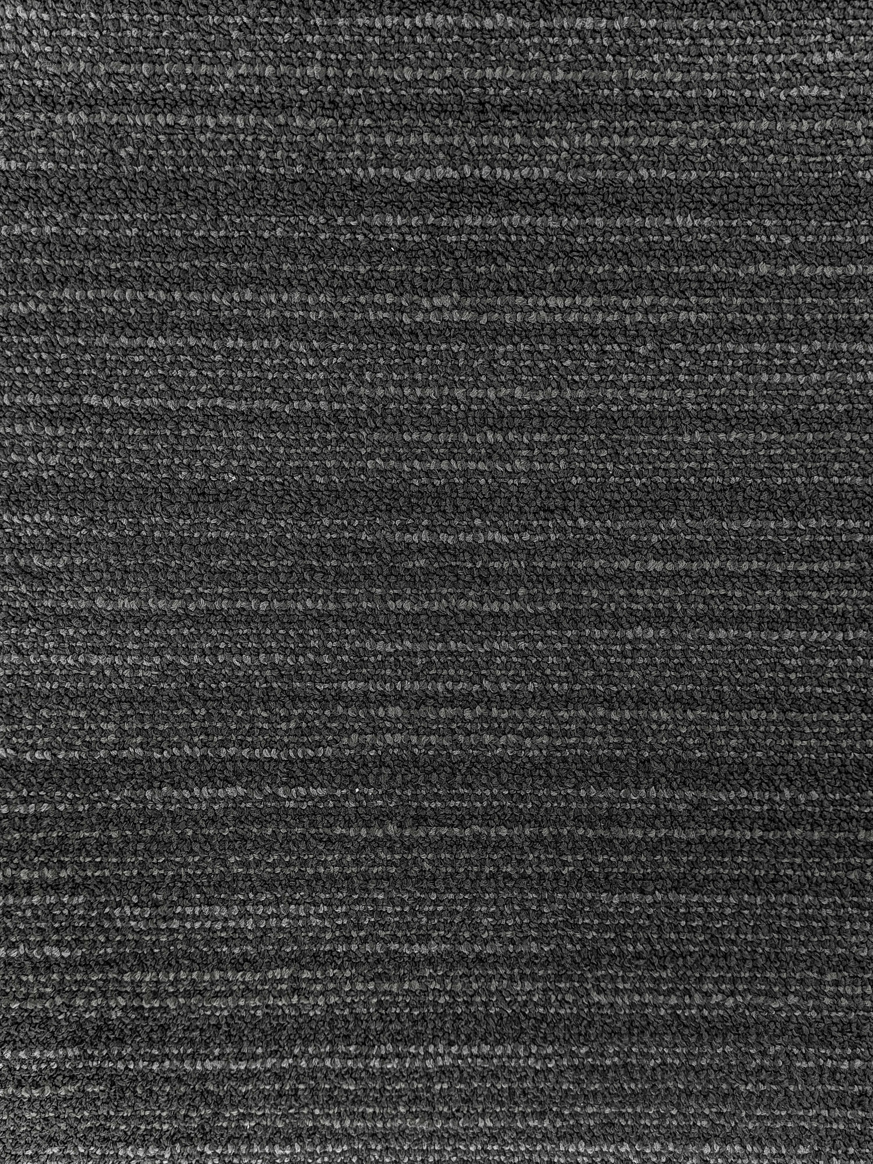 Close-up of a dark, striped fabric texture with tightly woven fibers and subtle tonal variation.