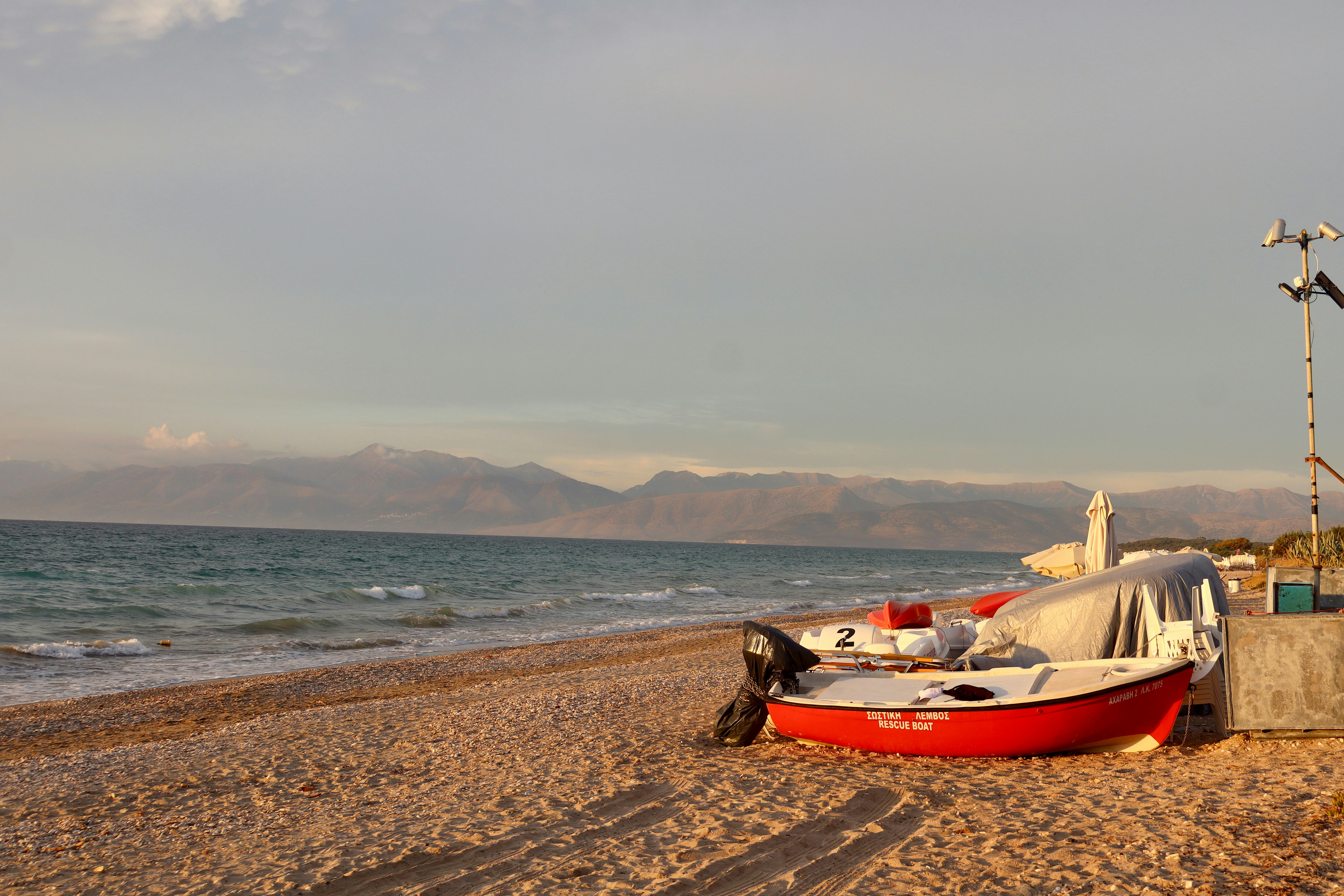 Red Boat Resting on Sunlit Shore