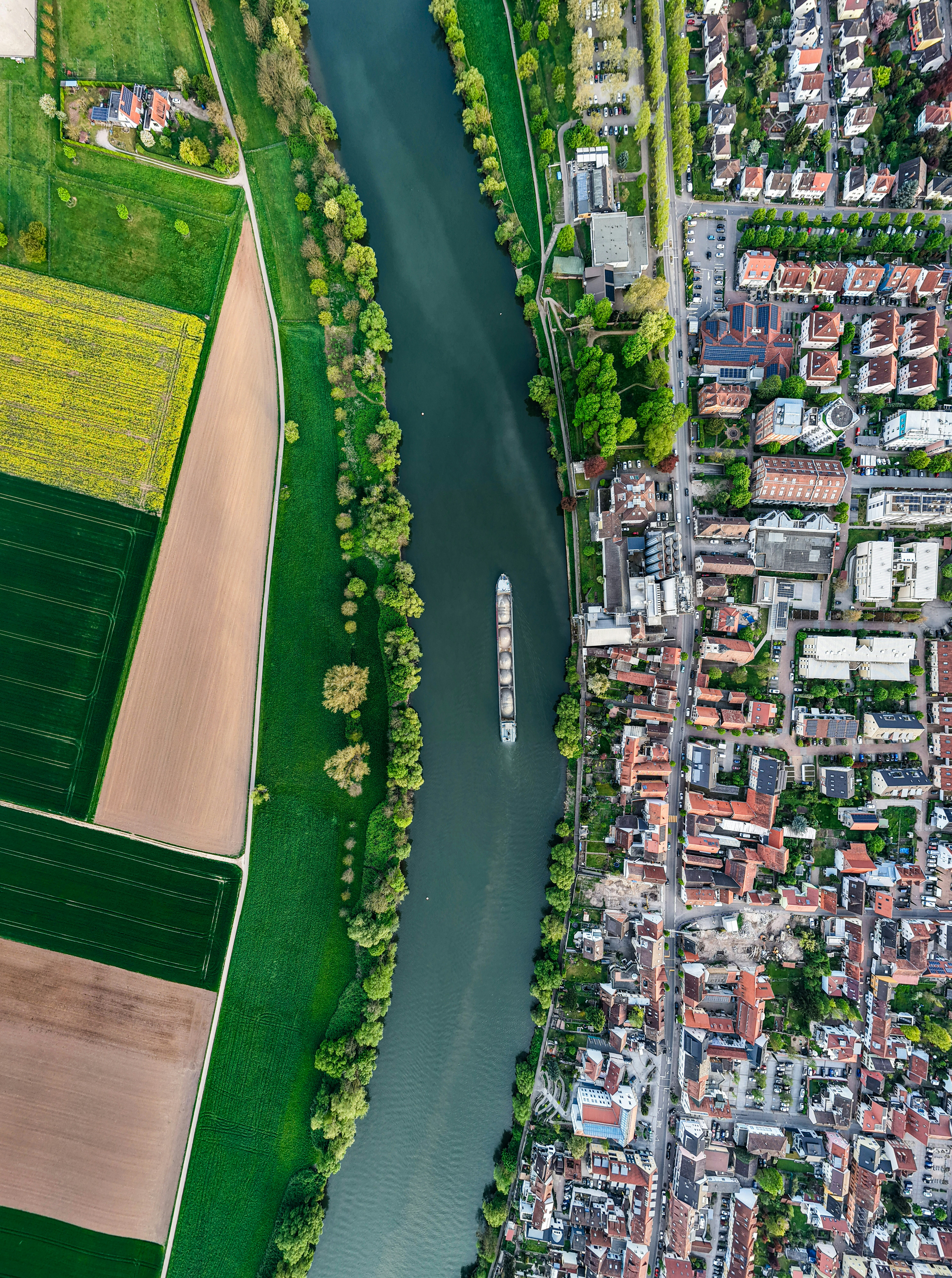 River Corridor Vein: Aerial View of Urban Grid Beside a Quiet Waterway