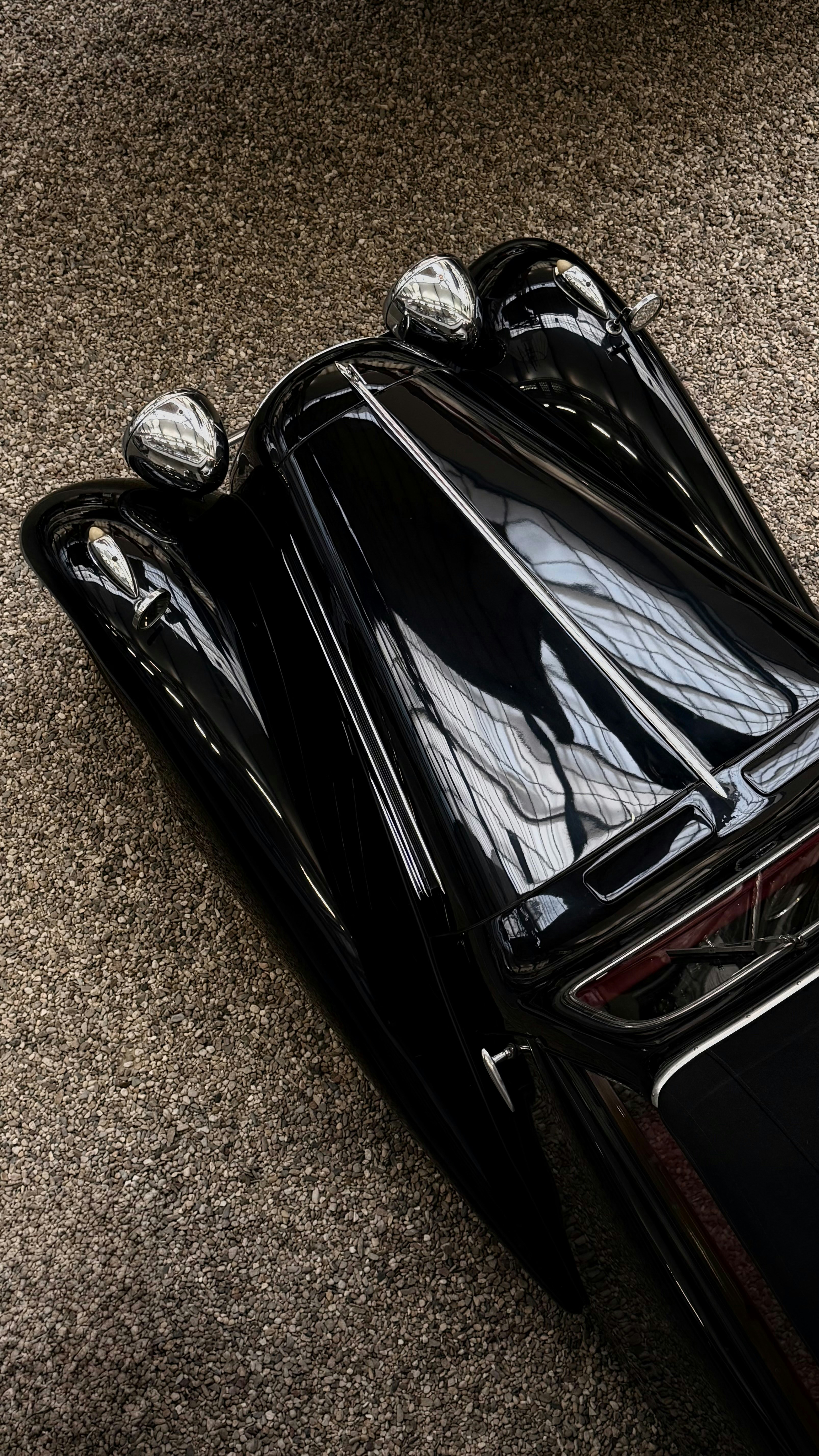 Shiny black vintage car corners at a diagonal tilt