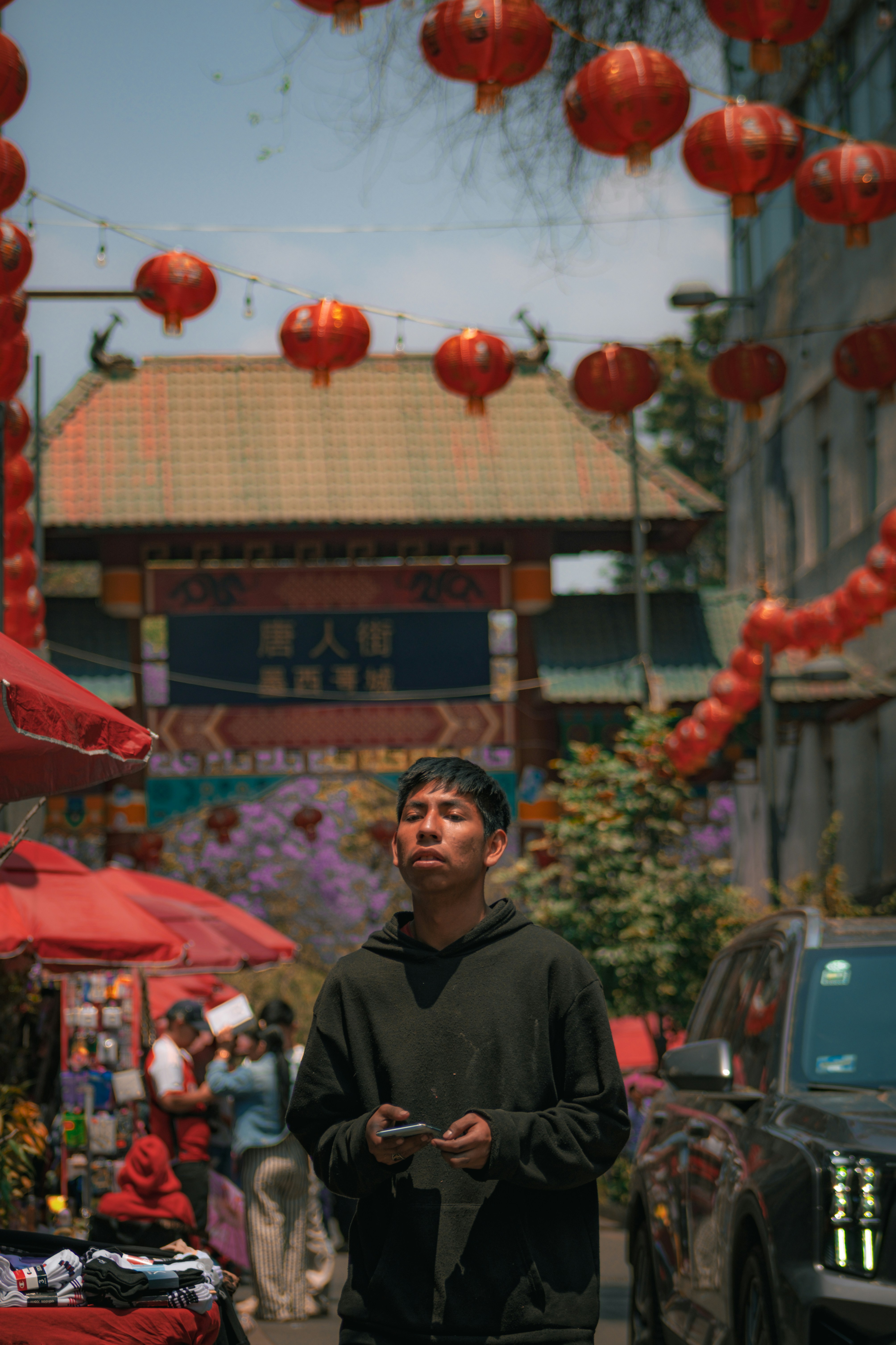 City Lanterns and Quiet Focus: A Portrait in the Market Alley