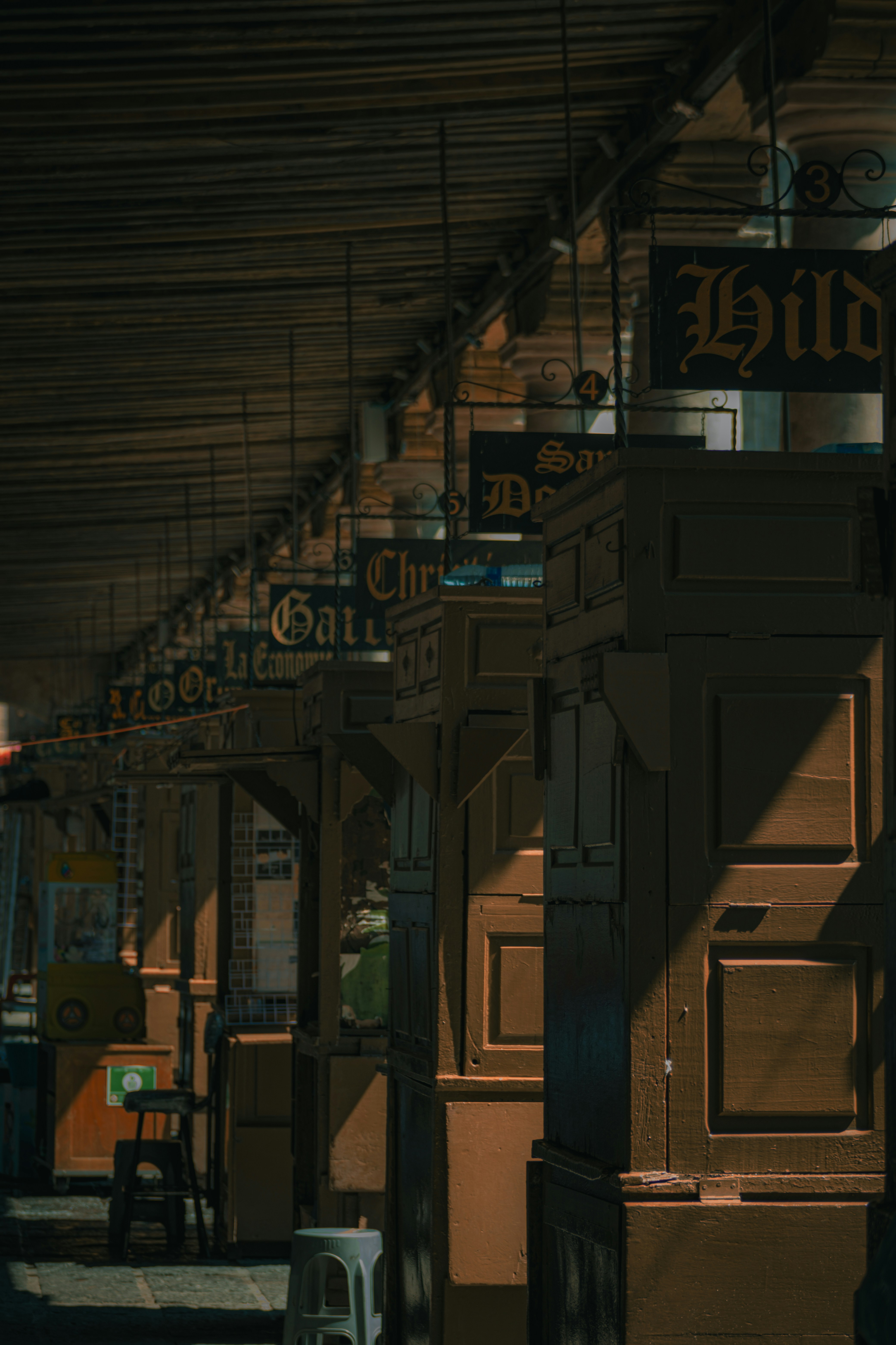Dusty arcade of shadows: a quiet corridor of old signs